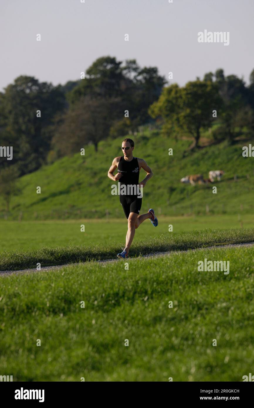 Male runner on path near Munsing, Upper Bavaria, Germany Stock Photo ...
