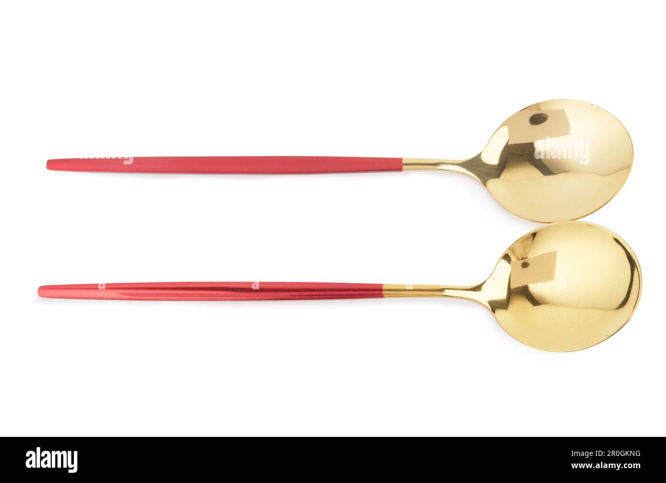 Golden spoons with red handles on white background Stock Photo - Alamy