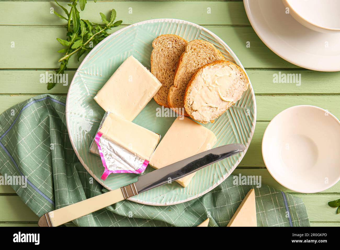 Plate and sandwich with processed cheese on green wooden background ...