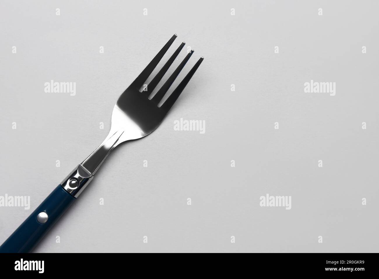 Stainless steel fork with plastic handle on grey background Stock Photo ...