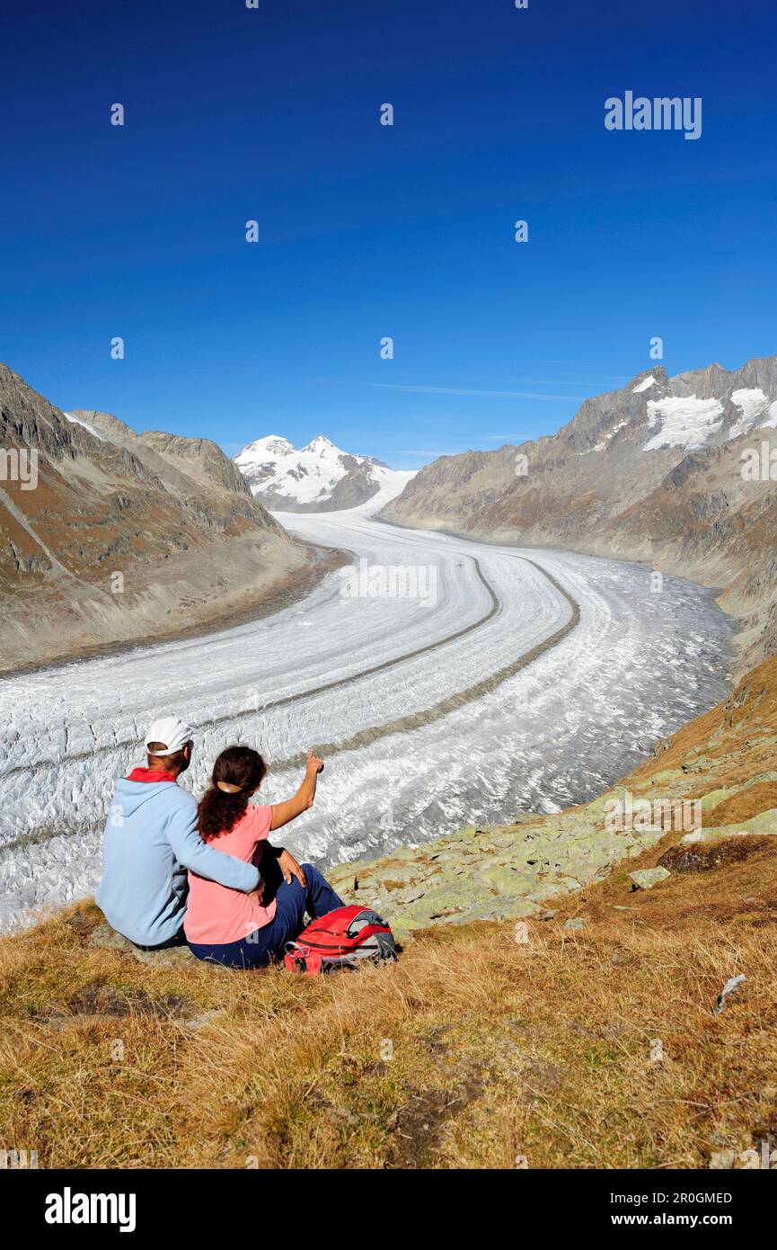 Couple looking towards glacier Grosser Aletschgletscher with Moench and ...
