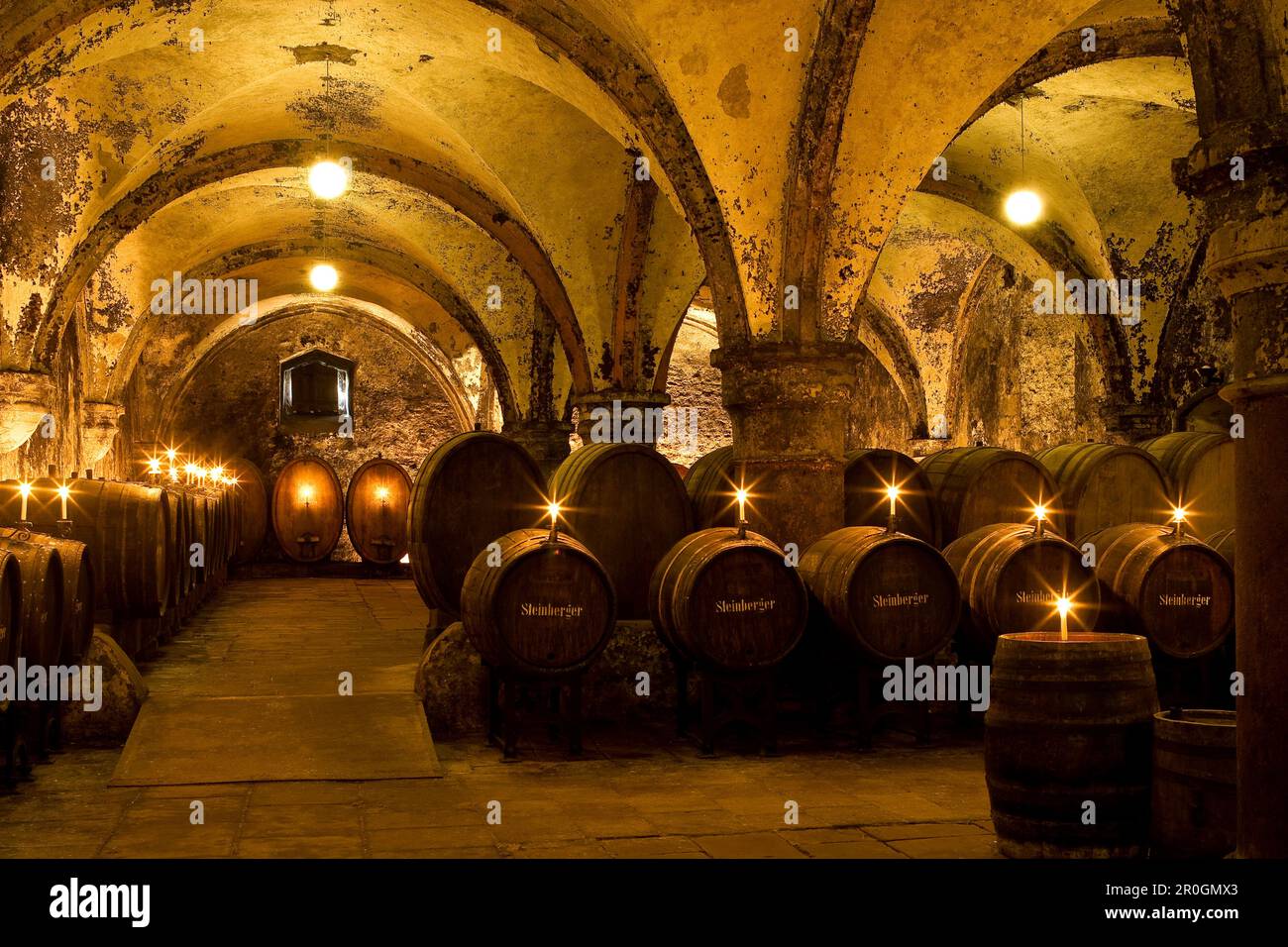 Candlelit barrels inside wine cellar of Eberbach abbey, a medieval ...