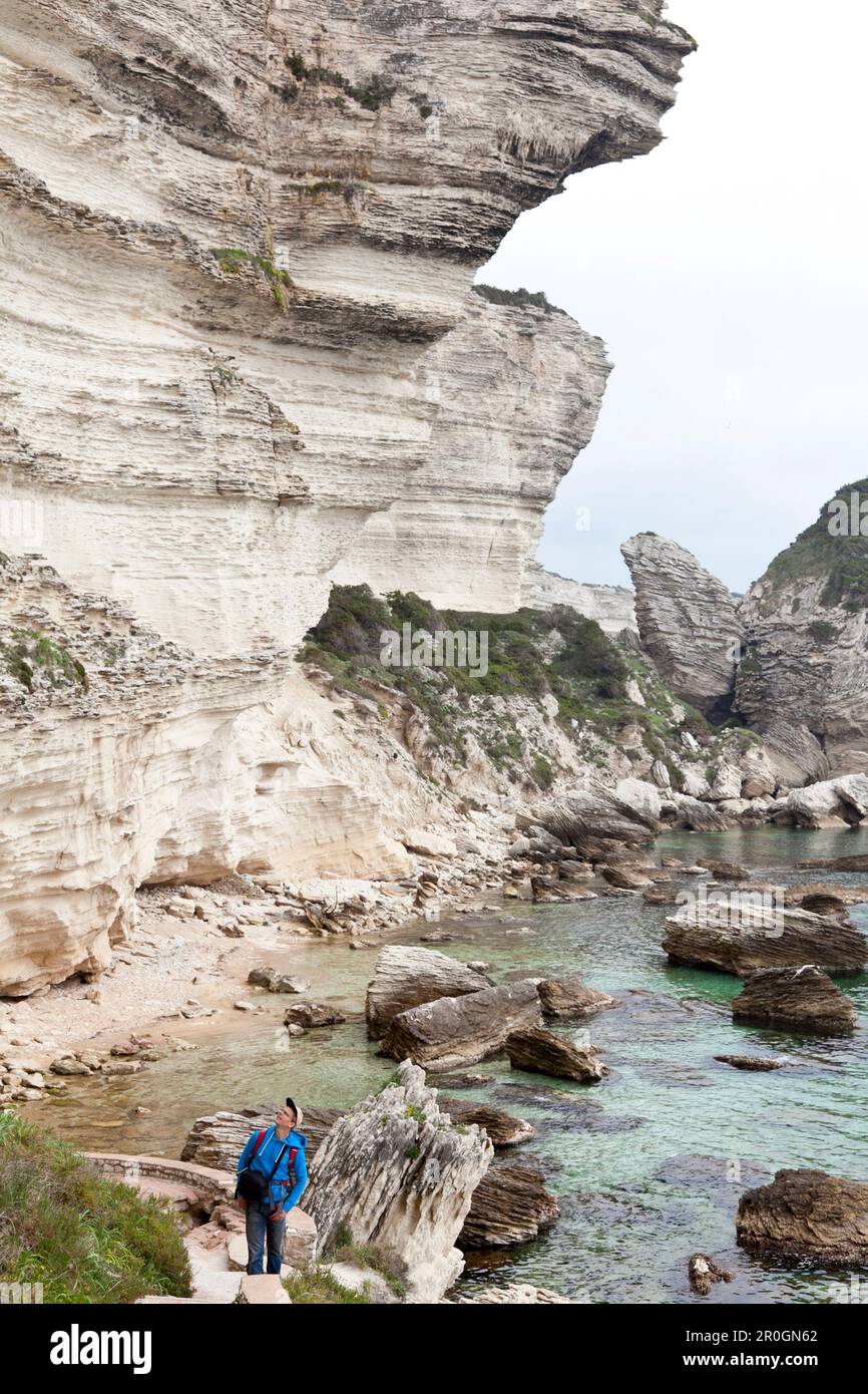 Coastal landscape at the foot of Bonifacio, tourist on rocks looking ...