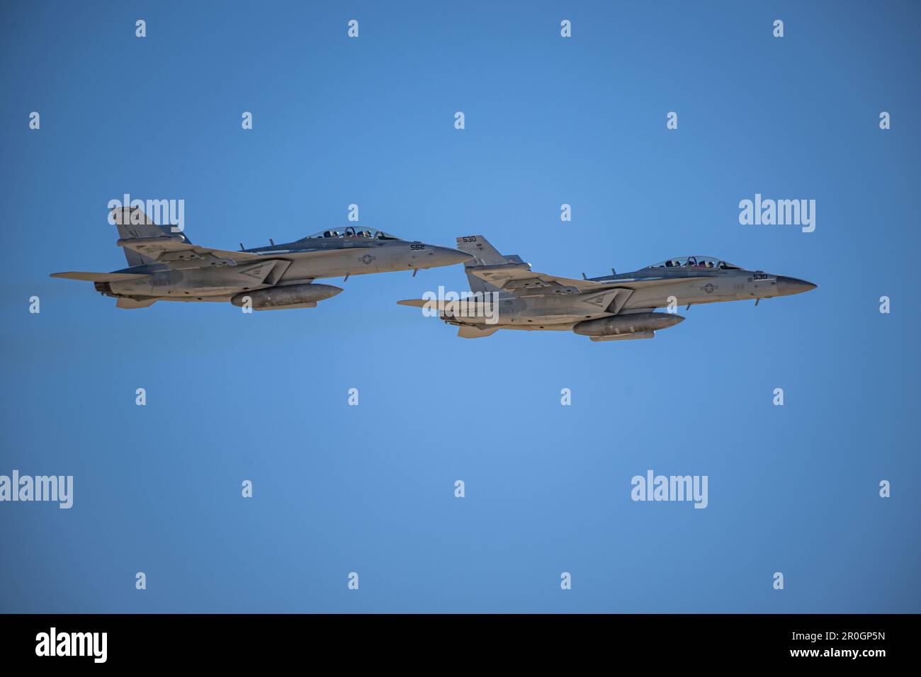 Two military fighter jets in flight performing an aerial display at an ...