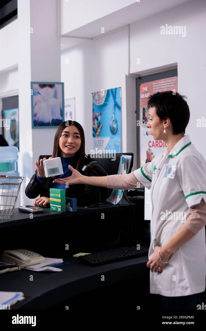 Apothecary customer asking pharmacist about vitamin at checkout ...