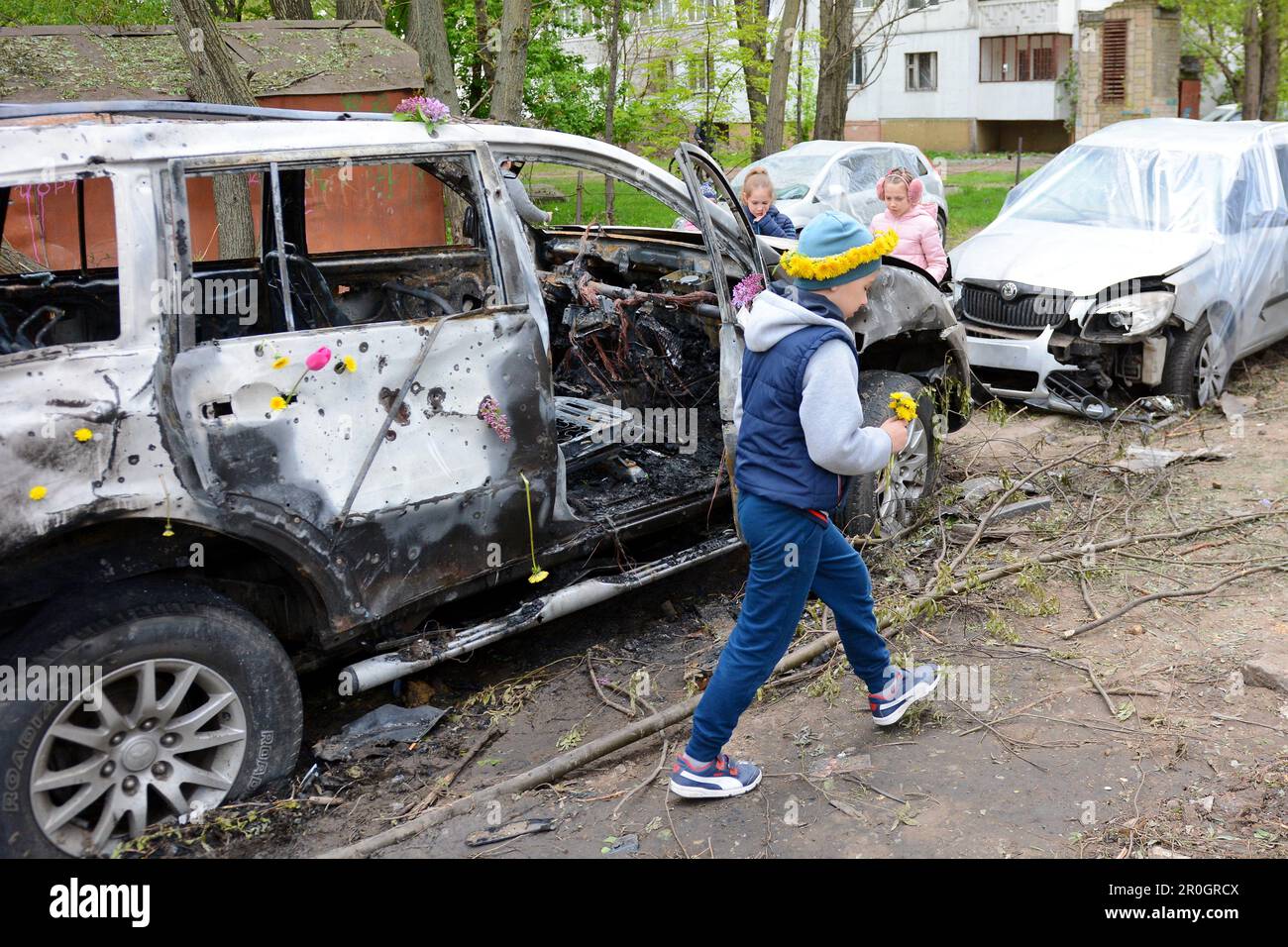 Children play next to the destroyed cars after the remains of a shot ...