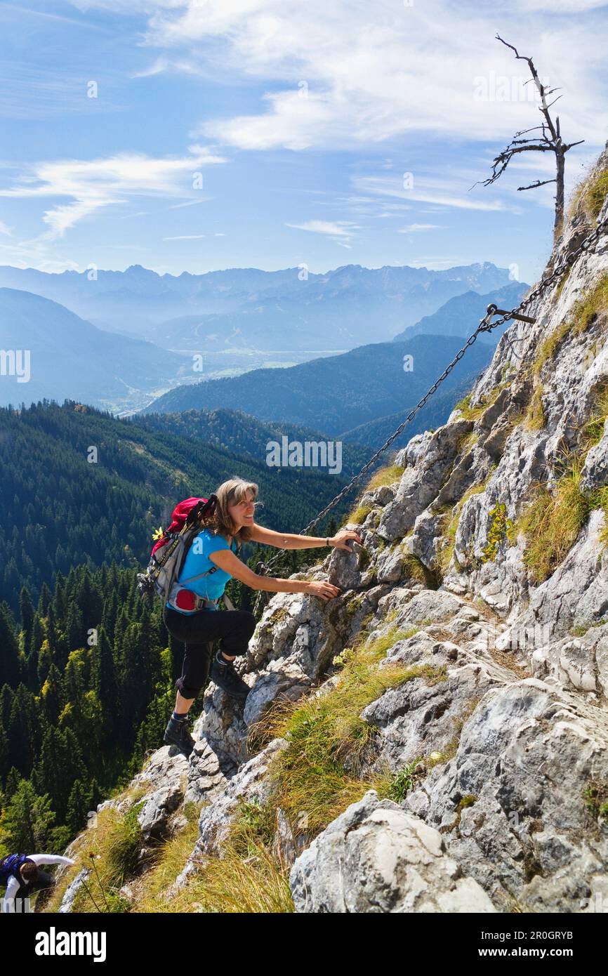 Woman climbing on Ettaler Mandl mountain, Laber, Ettal, Ammergauer Alps ...