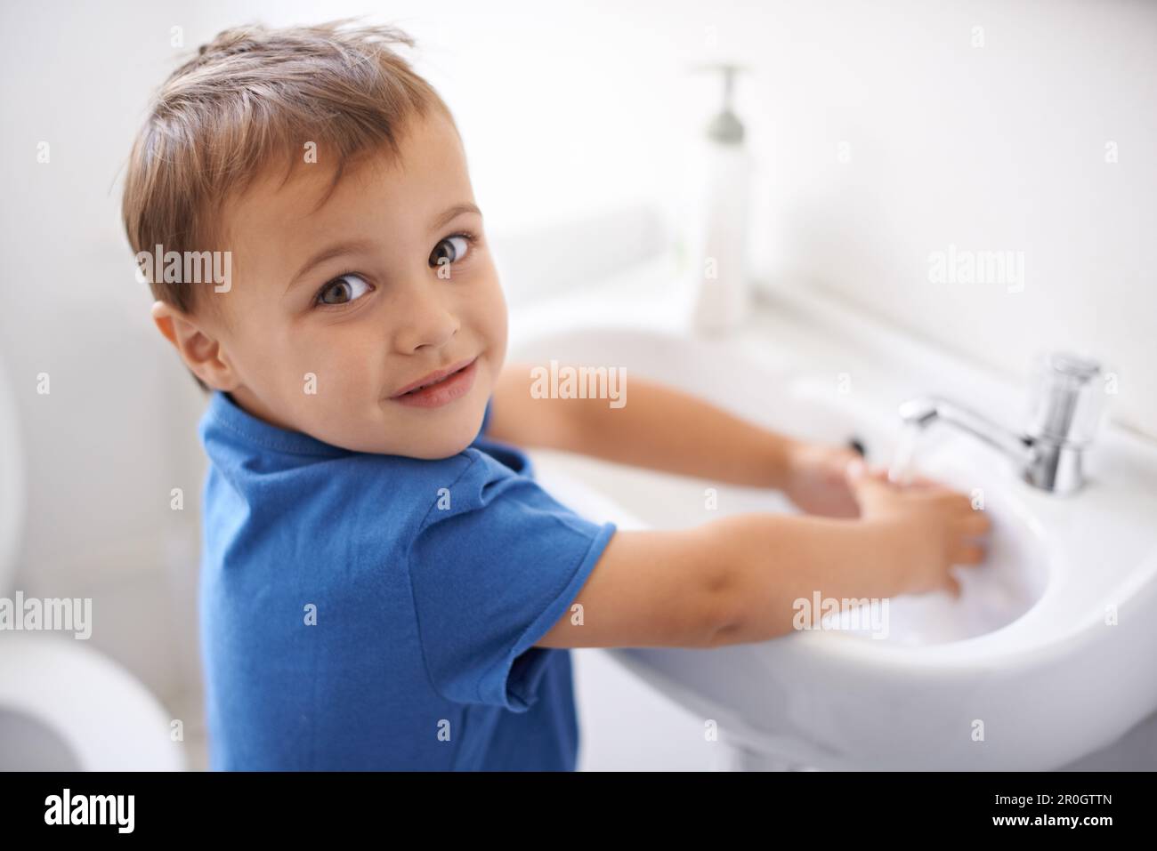 Banishing germs. Portrait of an adorable young boy washing his hands in ...