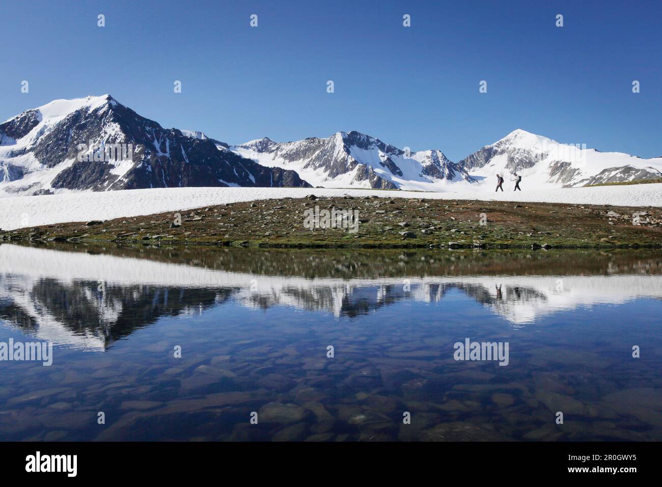 Mountaineers at Lake Brizzisee, Reflection of mountains in the lake ...