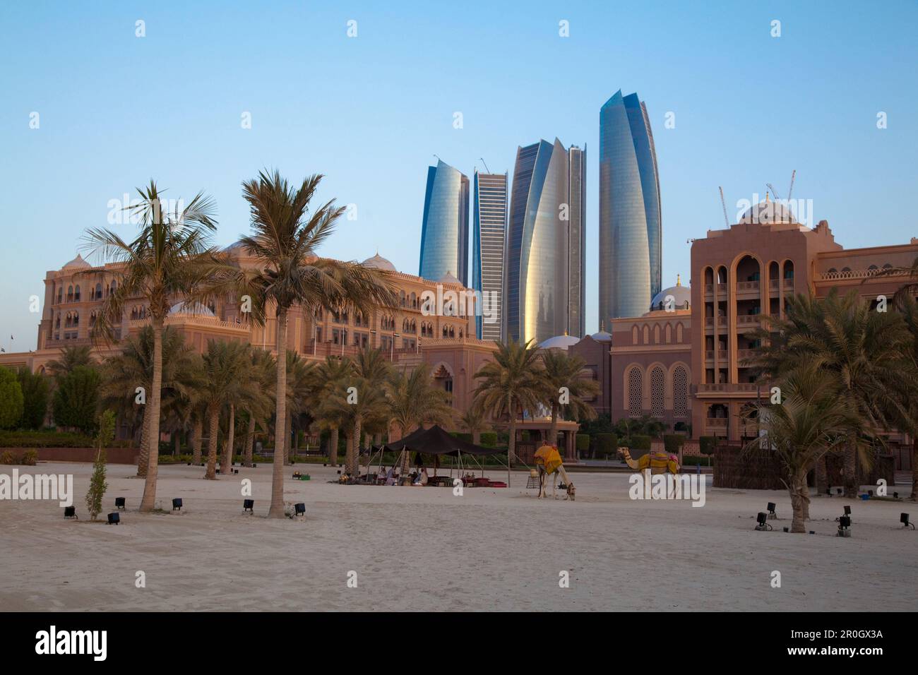 Sandy beach with palms, Emirates Palace hotel and high rise buildings ...