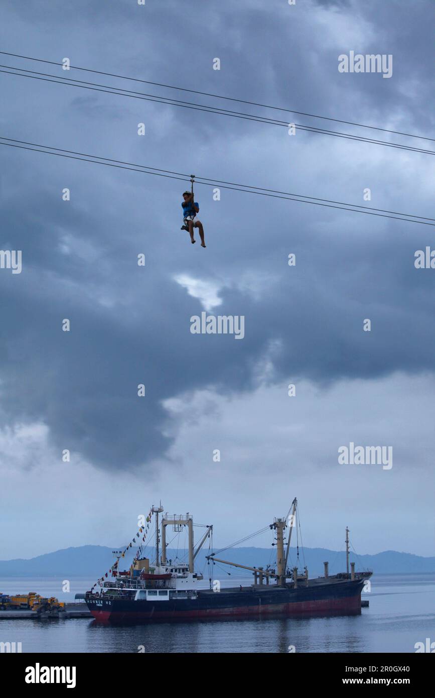 Man on zipline over bay of Legazpi City, Legazpi City, Luzon Island ...