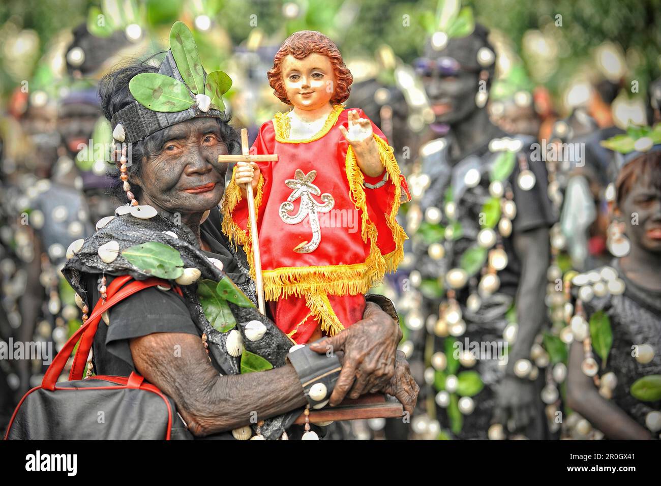 Old woman holding a Santo Nino figur, Ati Atihan festival, Kalibo ...