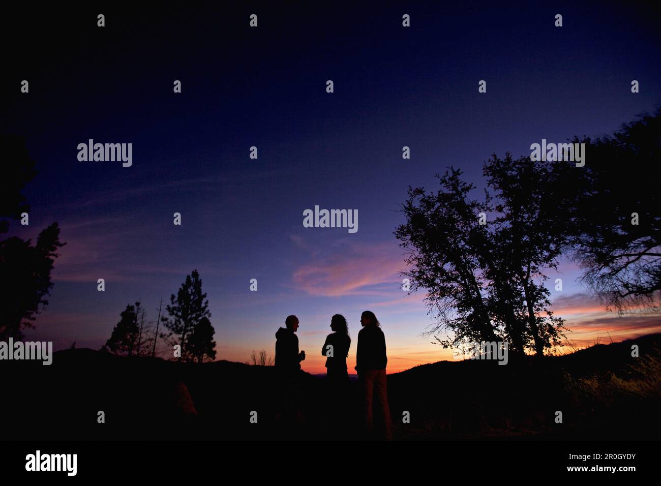 Three young people standing together and enjoying the sunset, Yosemite ...