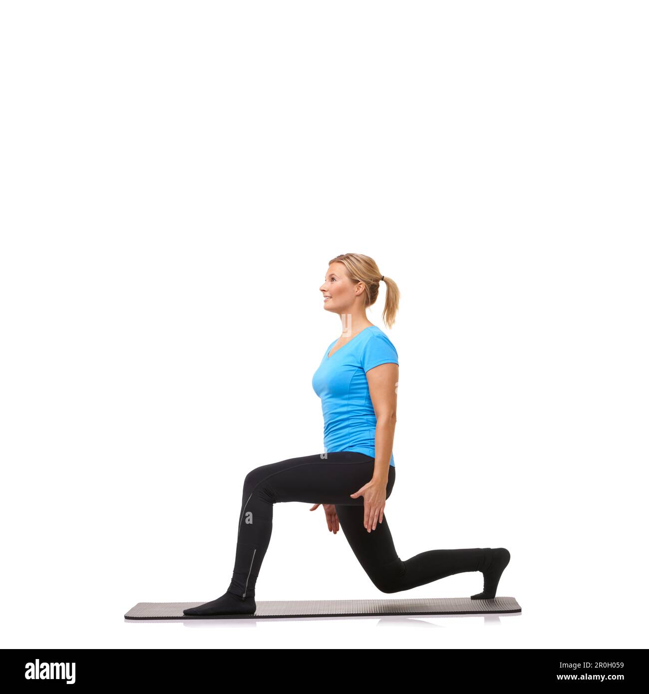 Doing her workout routine. A young woman performing lunges on her ...