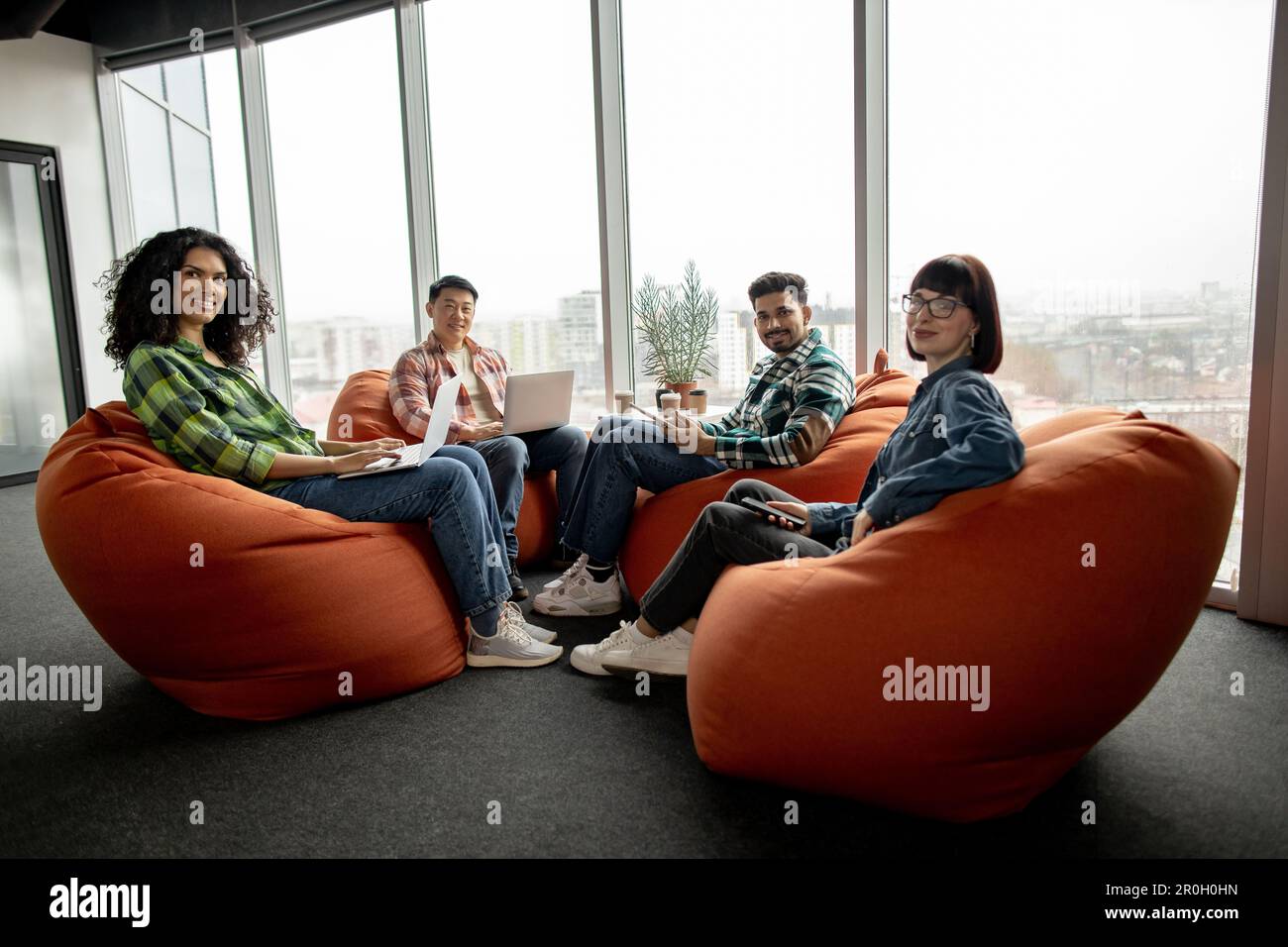 International men and women in everyday wear posing with handheld ...