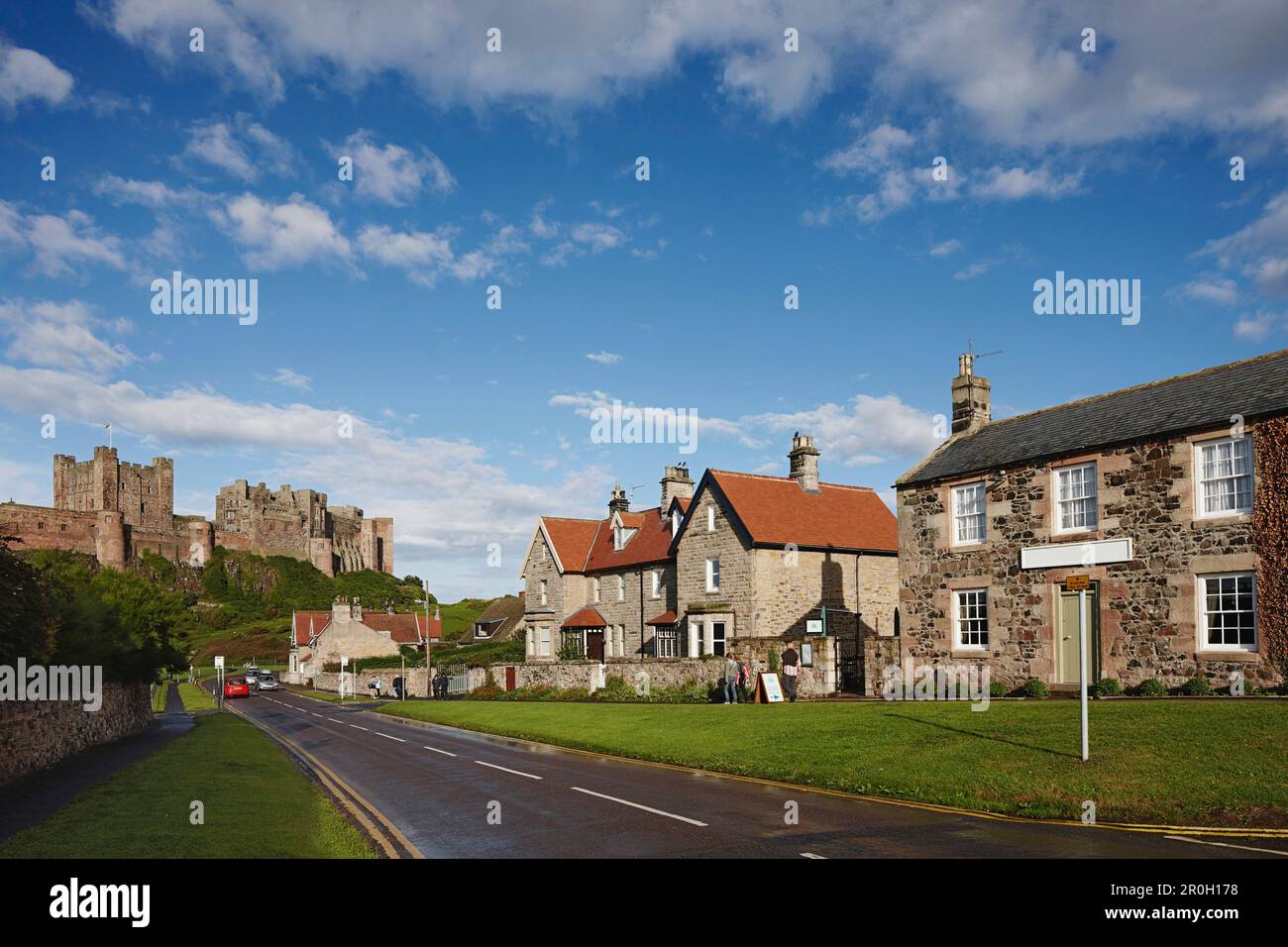 Street through Bamburgh village with view of Bamburgh Castle ...