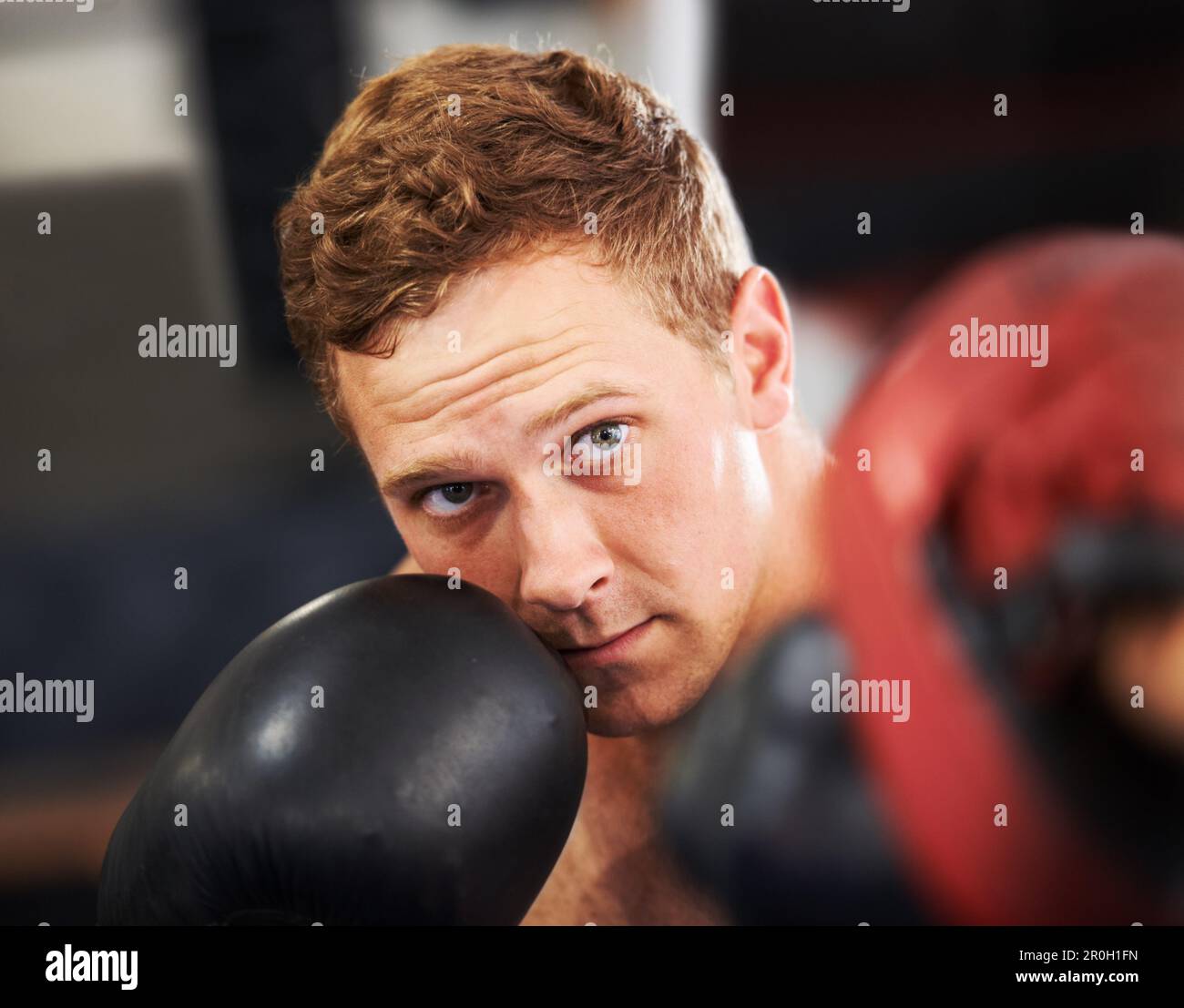 Perfecting his punch. A young boxer throwing a punch at his partners ...