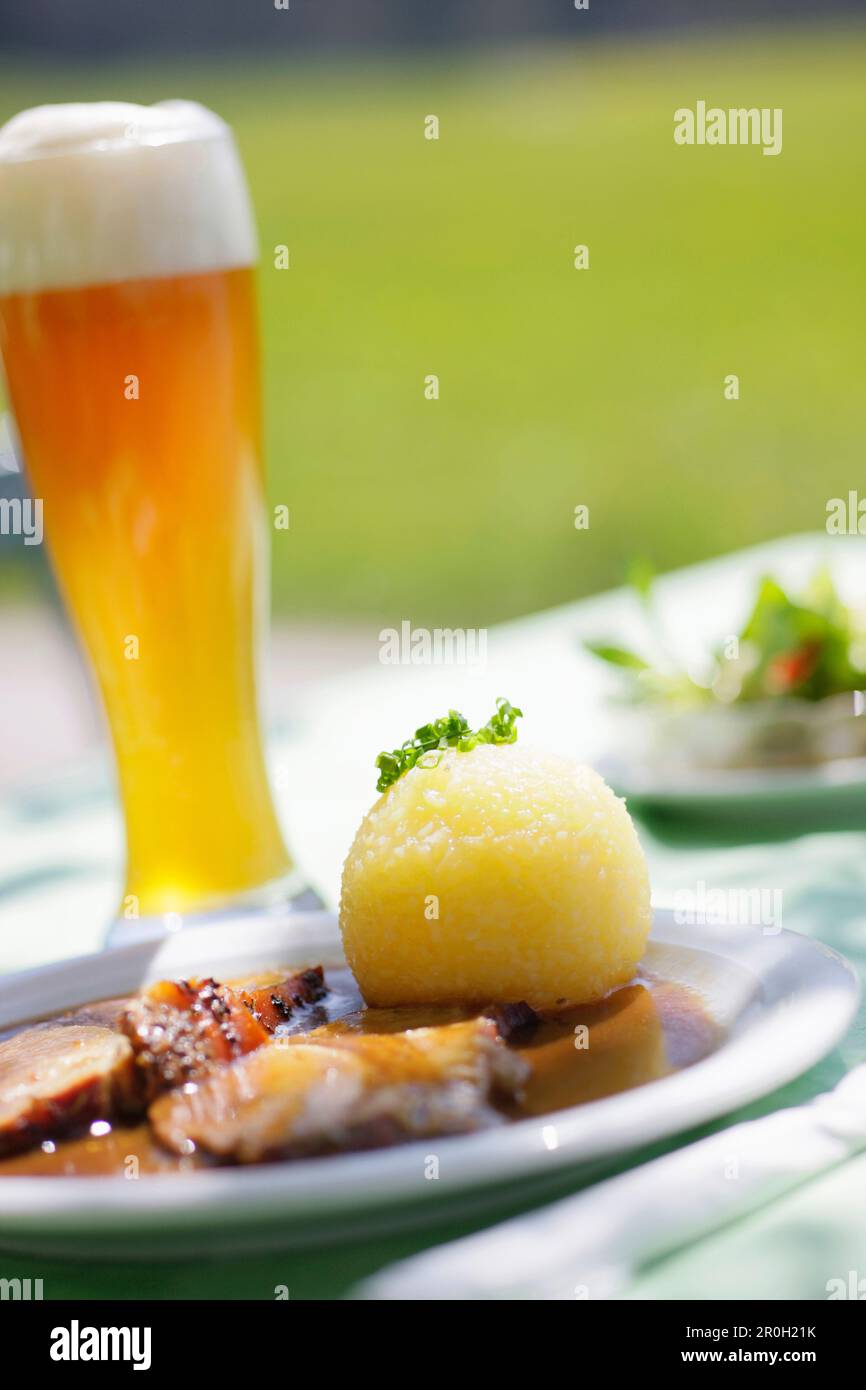Roast pork and wheat beer, weiss beer in a beer garden near Kochel ...
