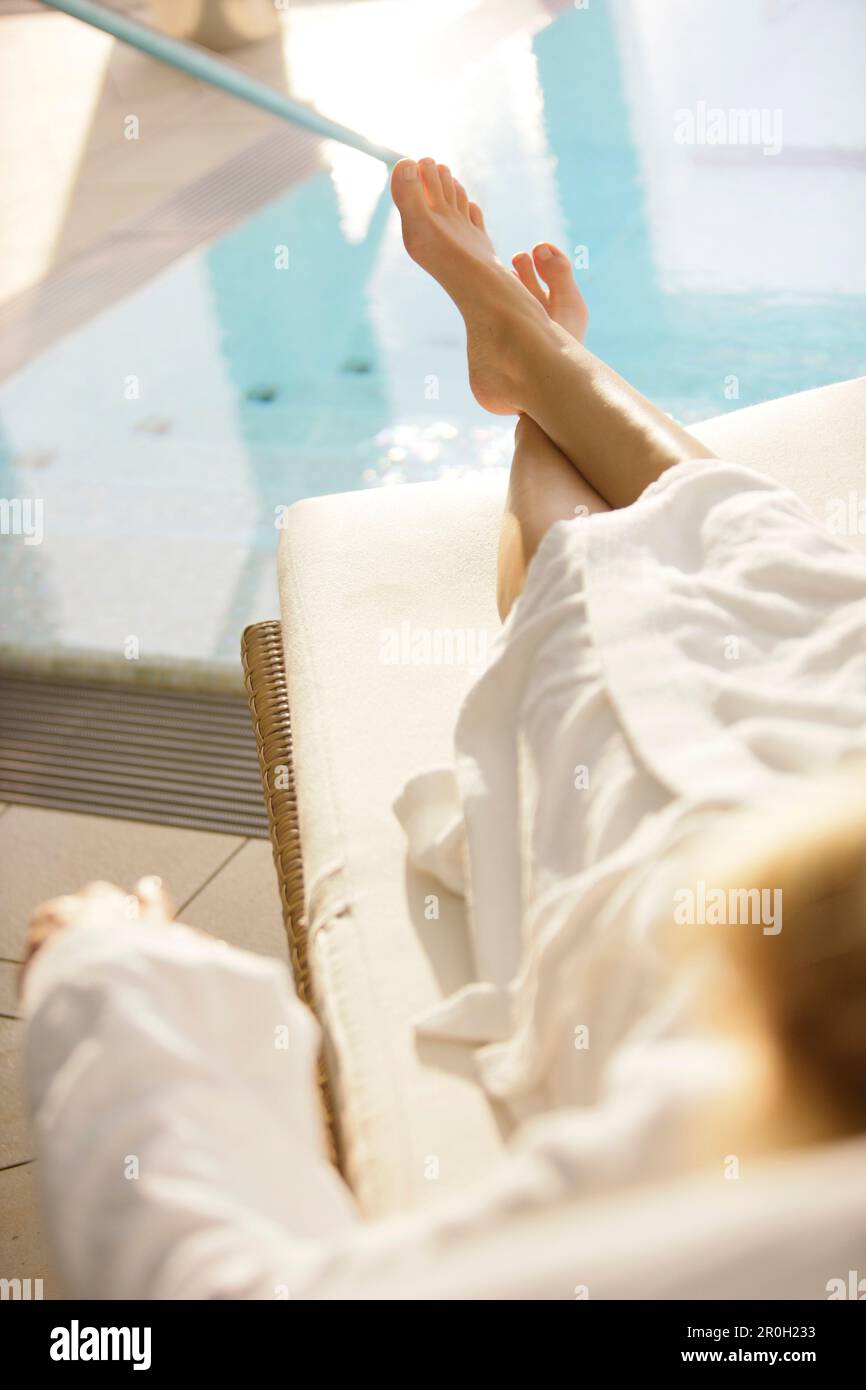 A woman lying on a sun lounger at a pool Stock Photo - Alamy