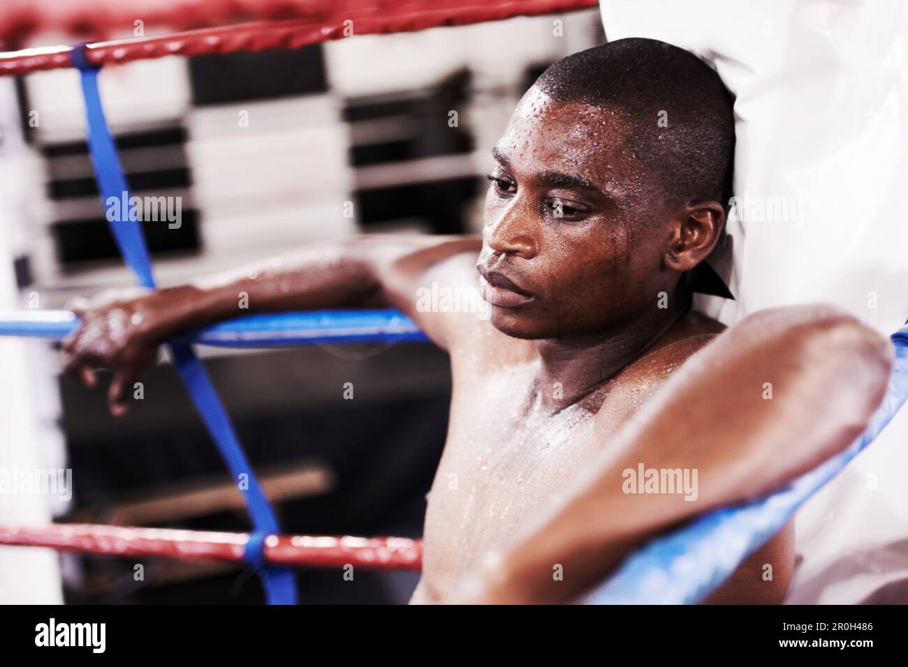 The sweat is pouring...An exhausted young boxer leaning against the ...