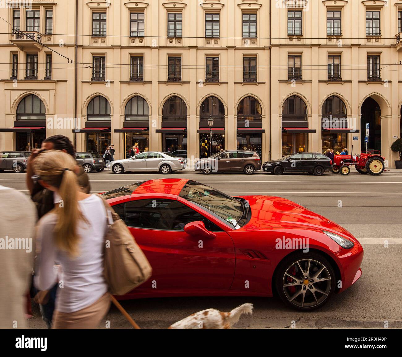 Red Ferrari and tractor in Maximilian street, shopping girl with dog ...
