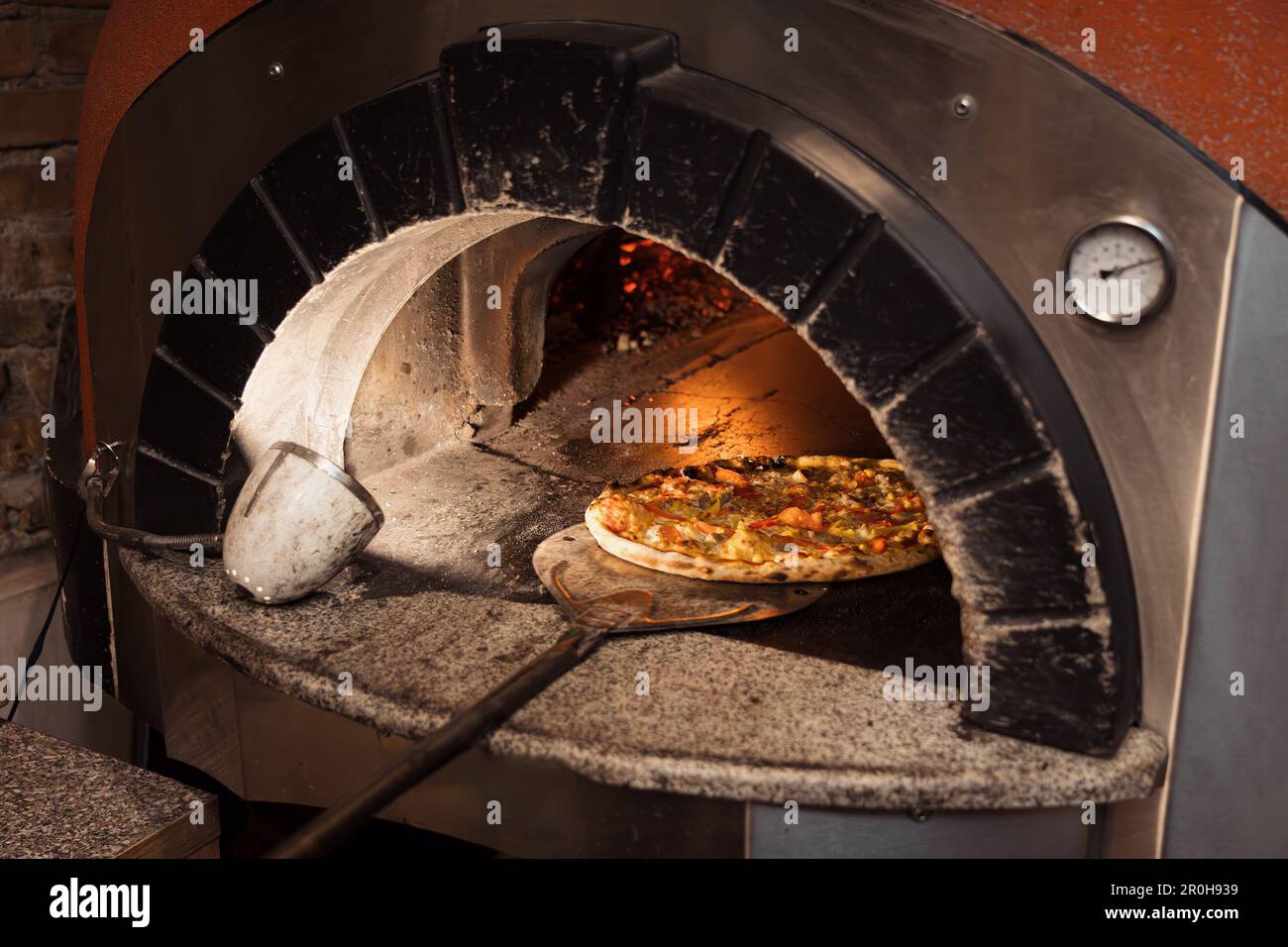 Preparing traditional italian pizza in a professional oven with open ...