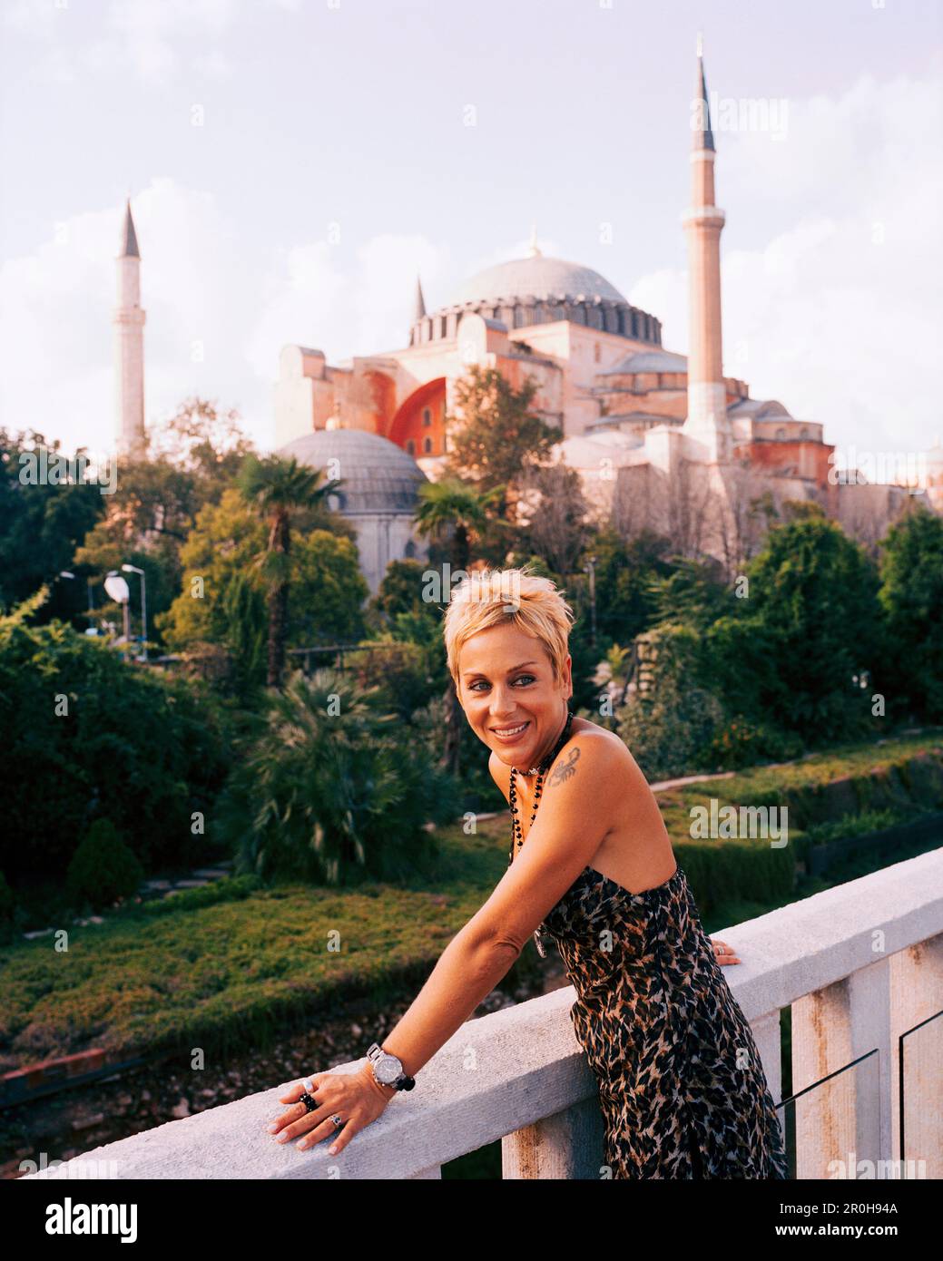 TURKEY, Istanbul, smiling lady looking away with the Aya Sofya mosque ...