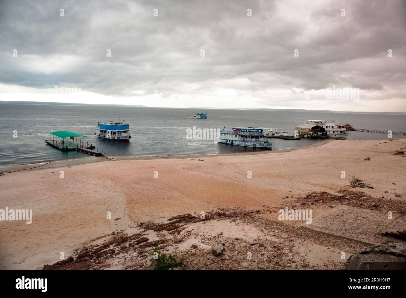 BRAZIL, Manaus, boat driving on the Amazon River under a dramatic sky ...