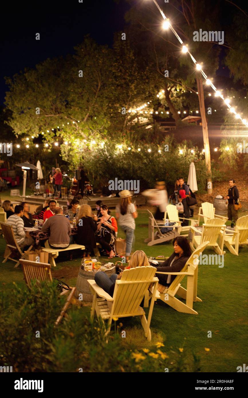 USA, California, Malibu, friends socialize and drink wine in the Malibu ...