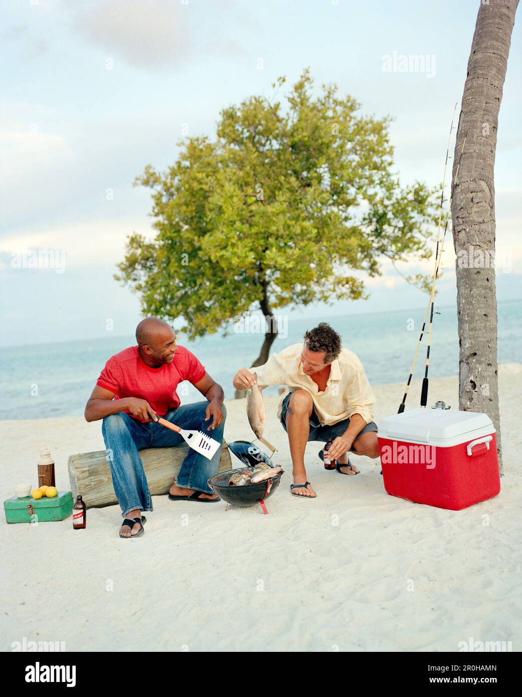 USA, Florida, friends having a beach BBQ, cooking fish, Islamorada ...