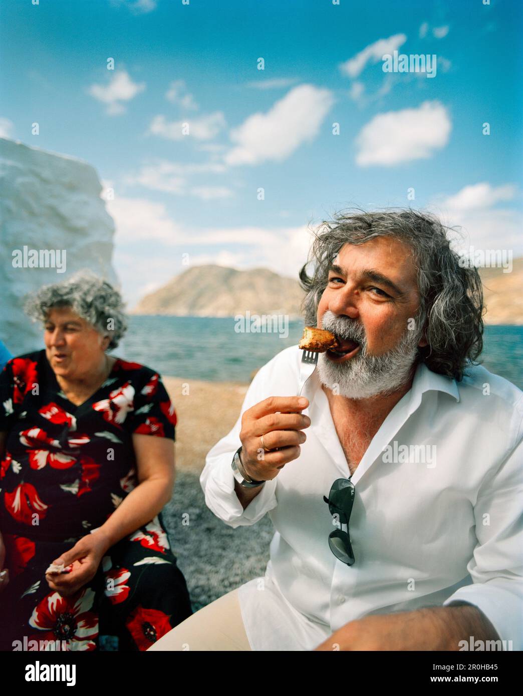 GREECE, Patmos, Diakofti, Dodecanese Island, Kostas enjoys a zucchini ...