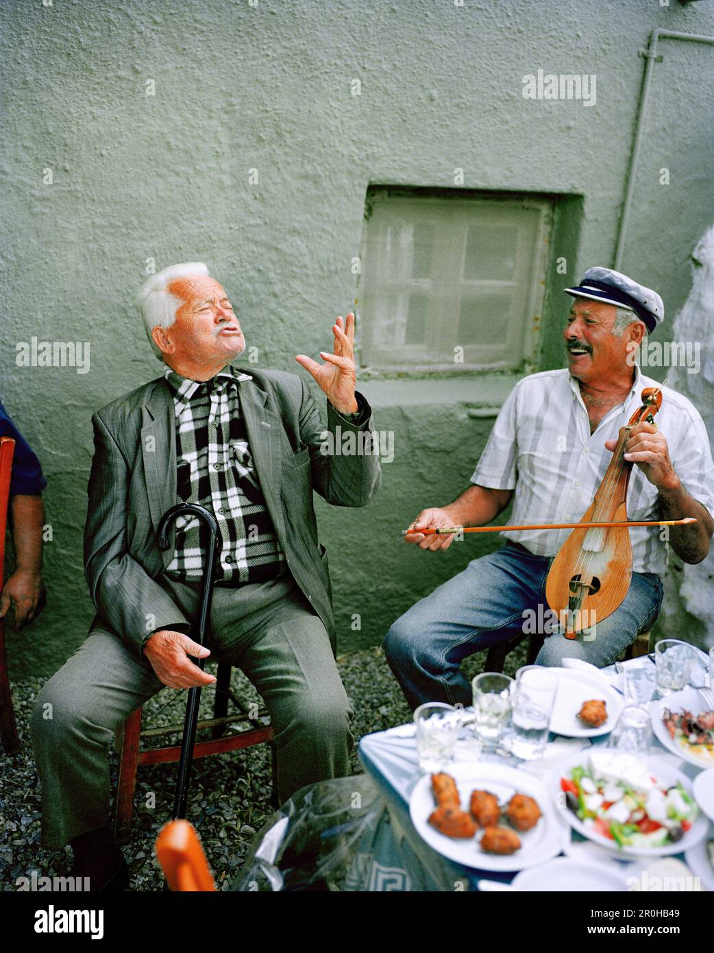 GREECE, Patmos Island, Michalis playing the lyra and while his friend ...