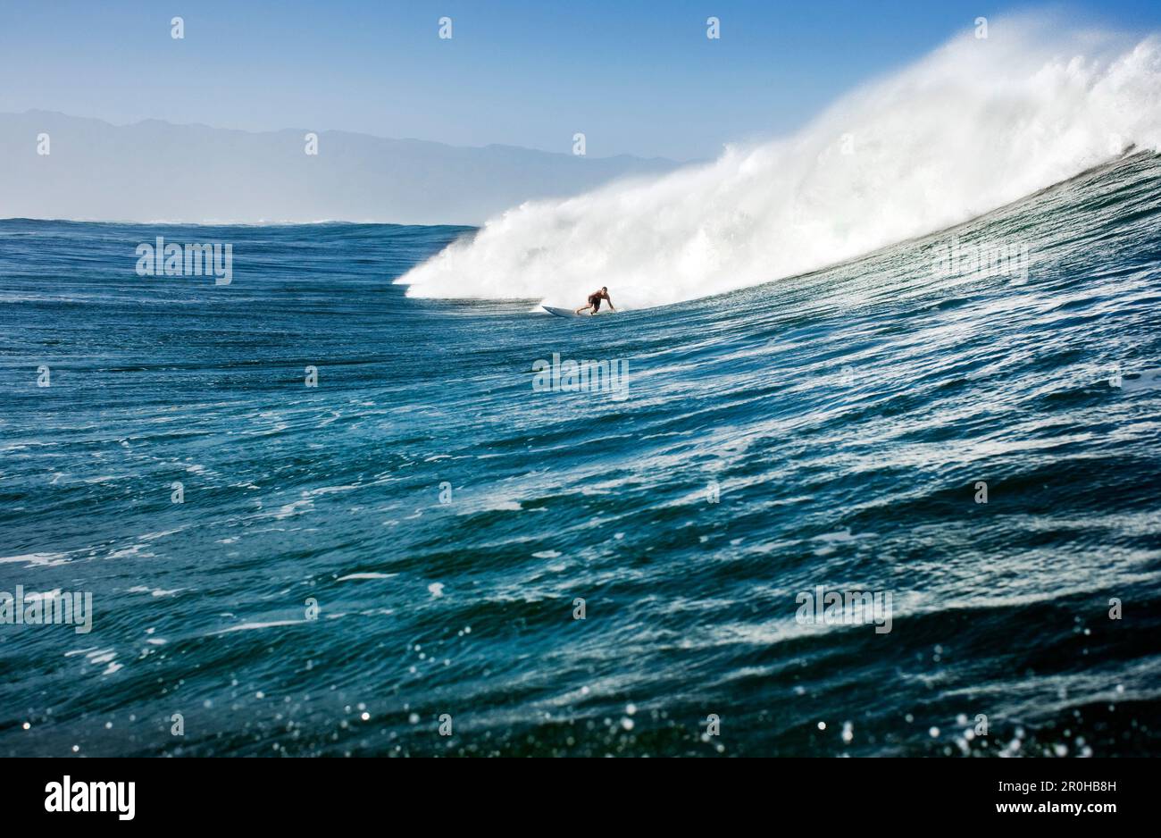 USA, Hawaii, man surfs a large wave on an outer reef, the North Shore ...