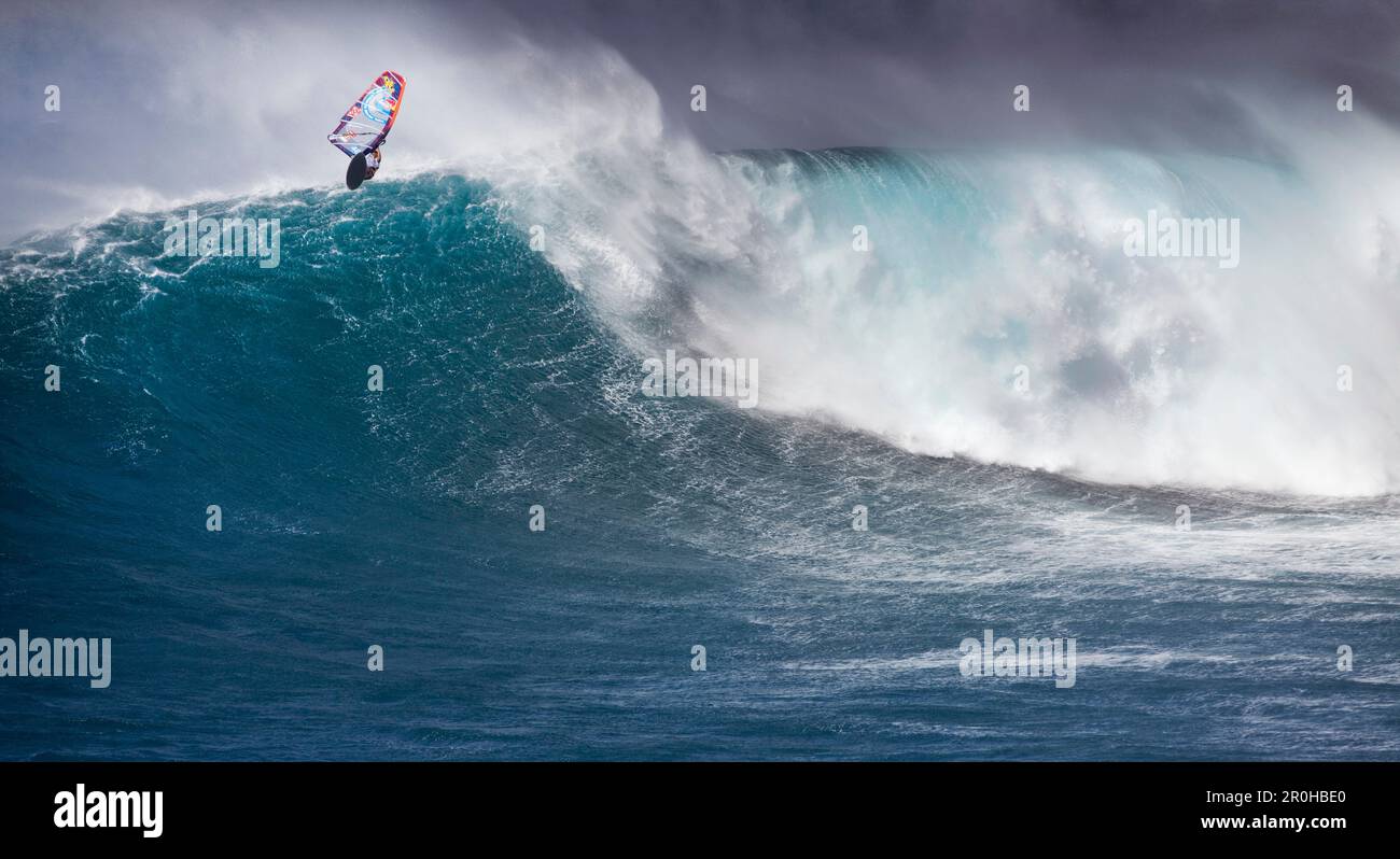 USA, Hawaii, Maui, a man windsurfs and gets air on a huge wave at a ...