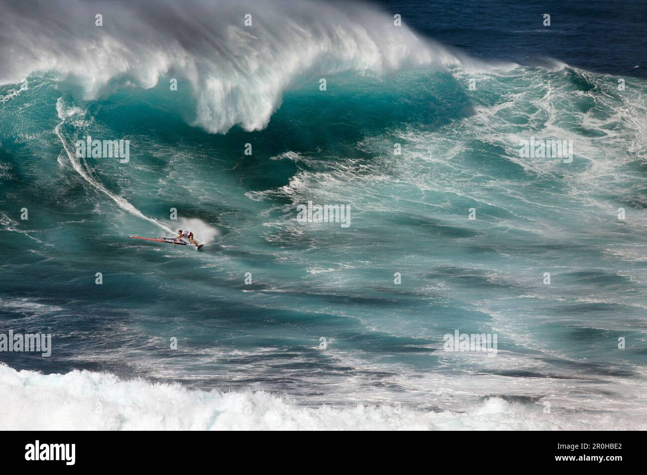 USA, Hawaii, Maui, a man windsurfs on huge waves at a break called Jaws ...