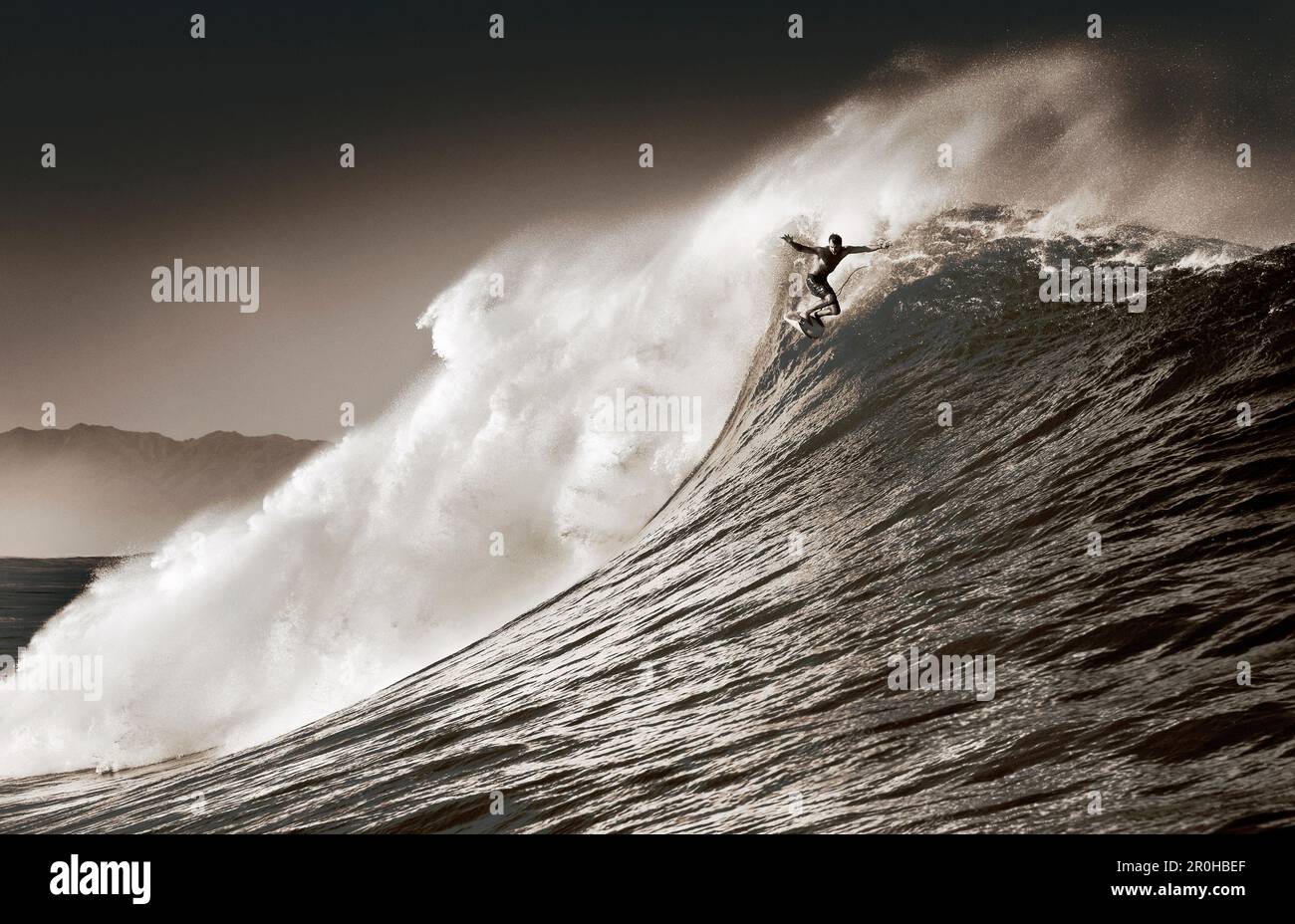 USA, Hawaii, man surfs a large wave on an outer reef, the North Shore ...