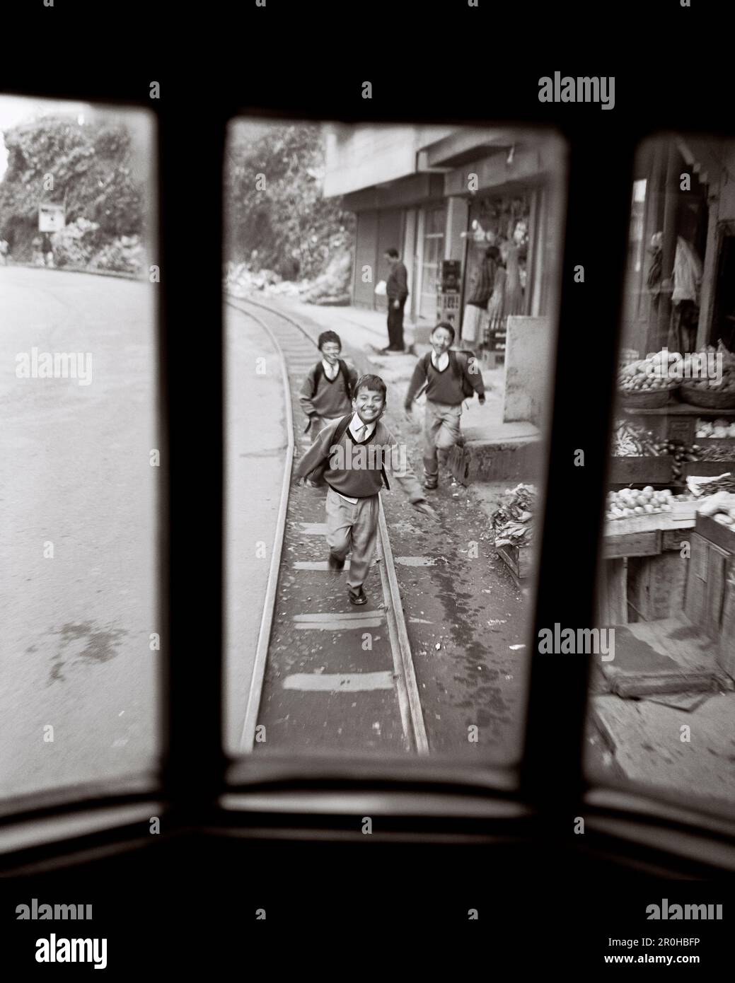 INDIA, West Bengal, school students chasing train on tracks, Darjeeling ...