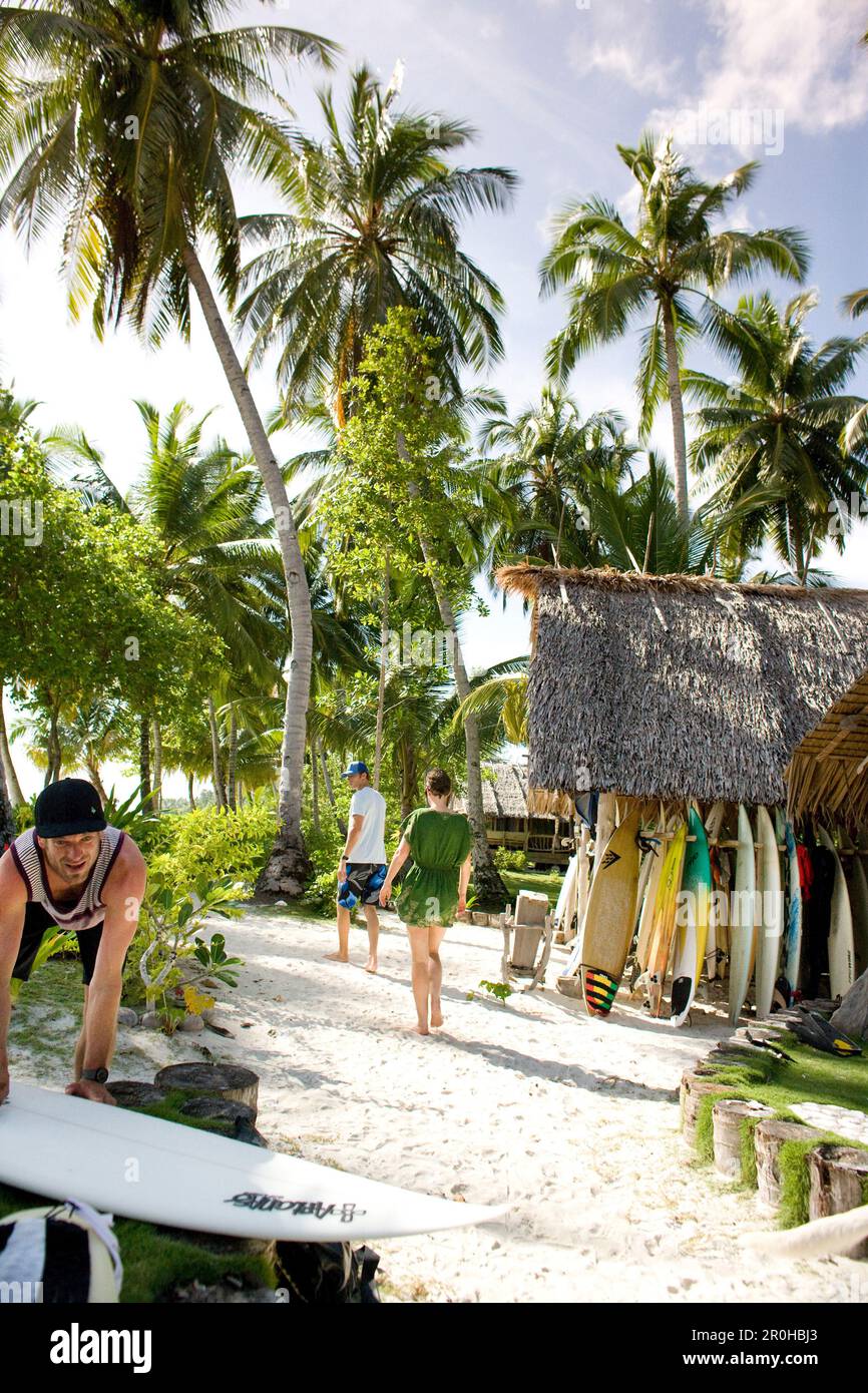 INDONESIA, Mentawai Islands, men and woman walking outside Kandui ...