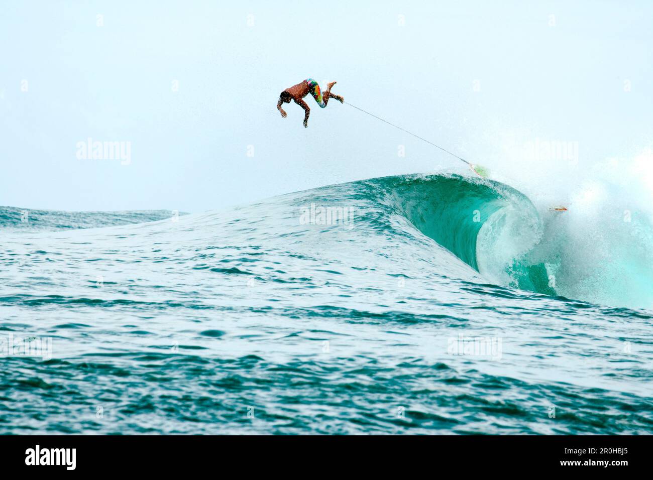 INDONESIA, Mentawai Islands, Kandui Resort, surfer diving over the back ...