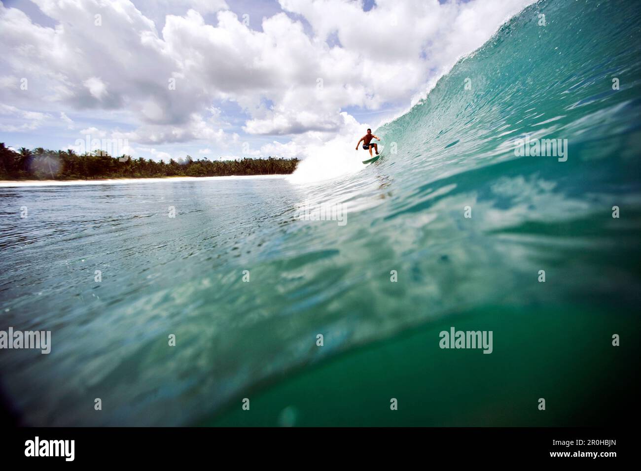 INDONESIA, Mentawai Islands, Kandui Resort, man surfing on a wave at a ...