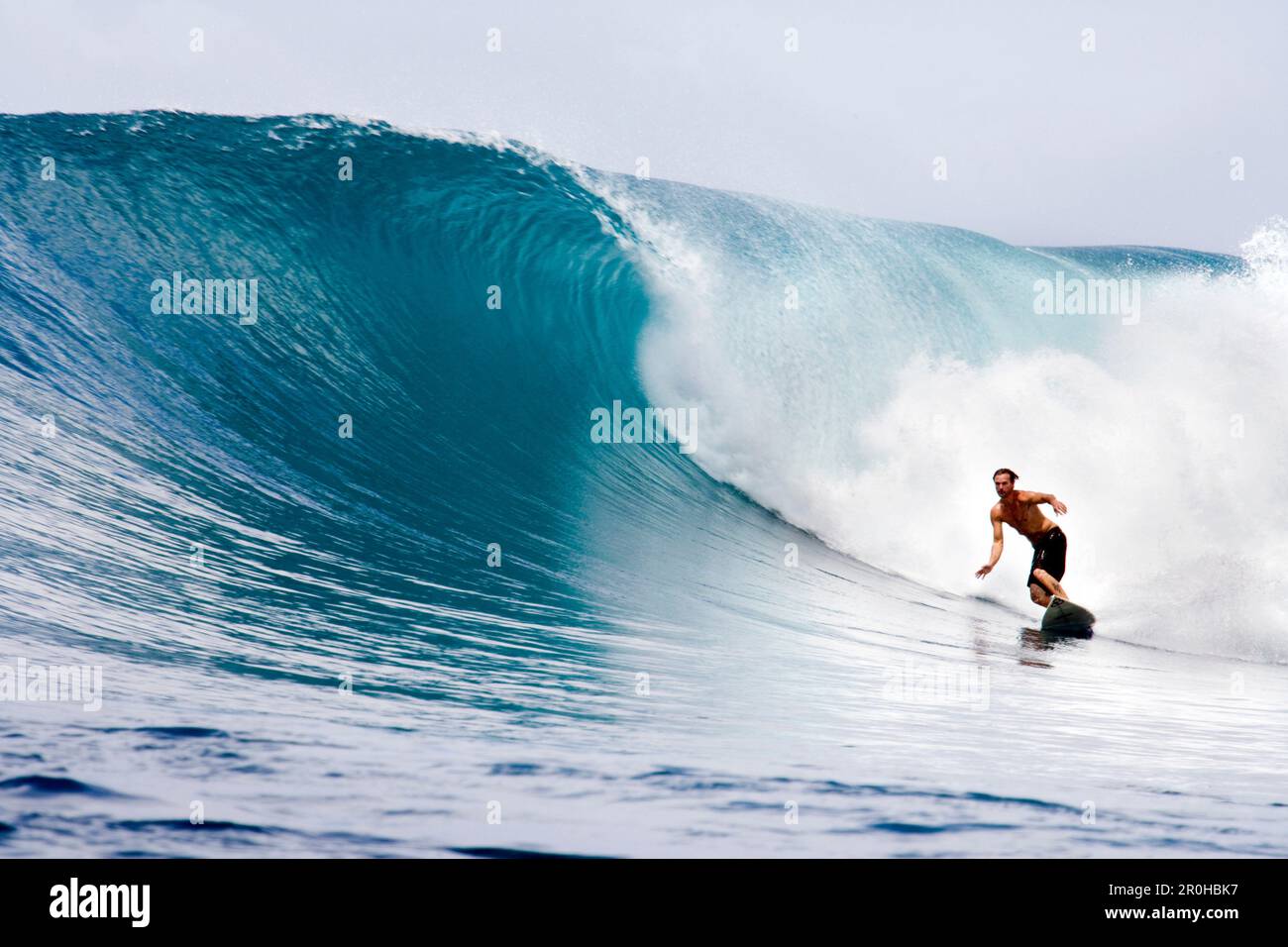 INDONESIA, Mentawai Islands, Kandui Resort, man surfing on a wave at a ...