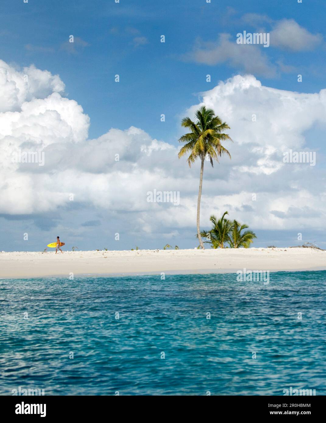 INDONESIA, Mentawai Islands, Kandui Resort, man walking with surfboard ...