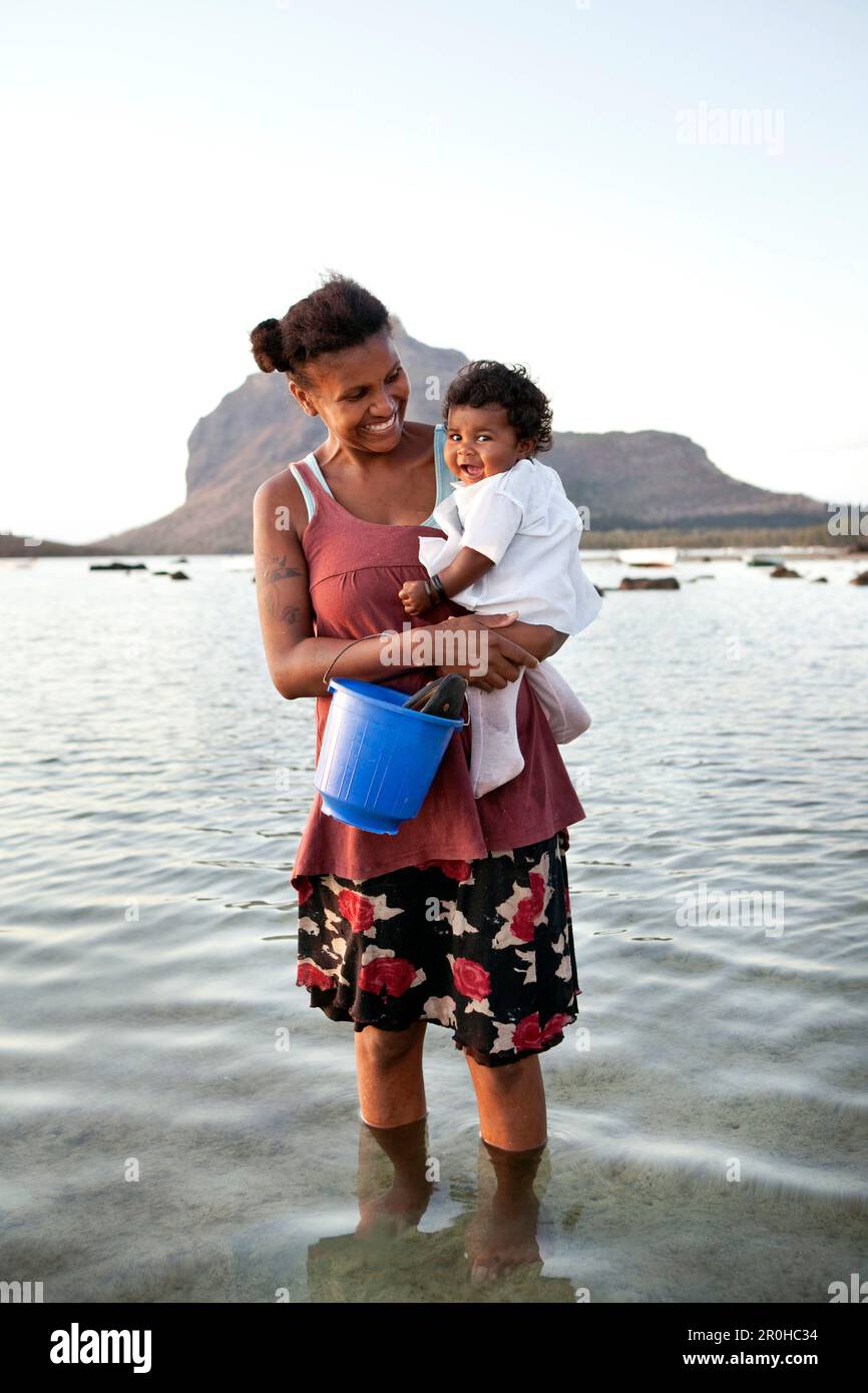 MAURITIUS, a mother and her child hunt for snails at low tide, Baie du ...