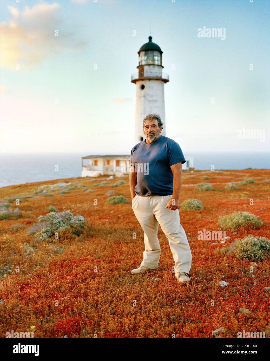 MEXICO, Baja, portrait of lighthouse keeper standing in front of ...