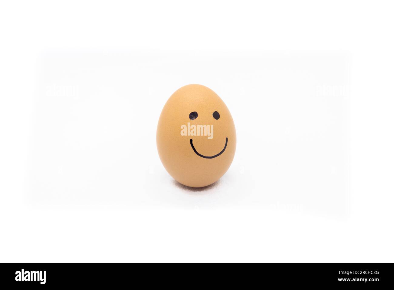 A yellow egg with a cheerful smiley face painted on its side Stock ...