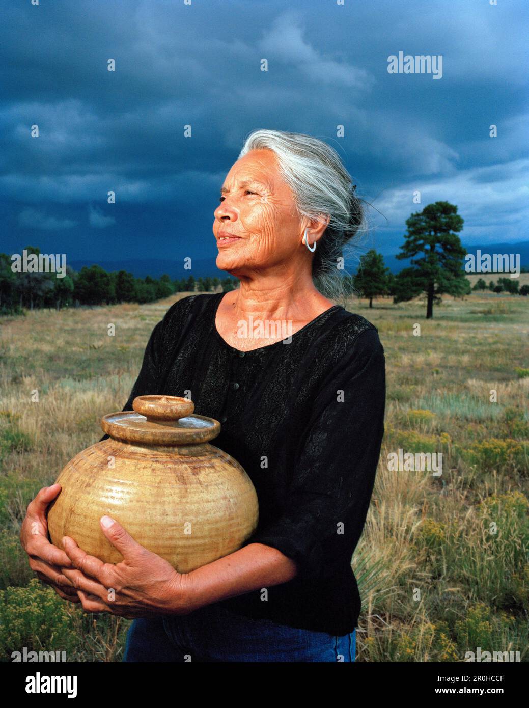 USA, New Mexico, beautiful Native American woman holding a pot, Valley ...