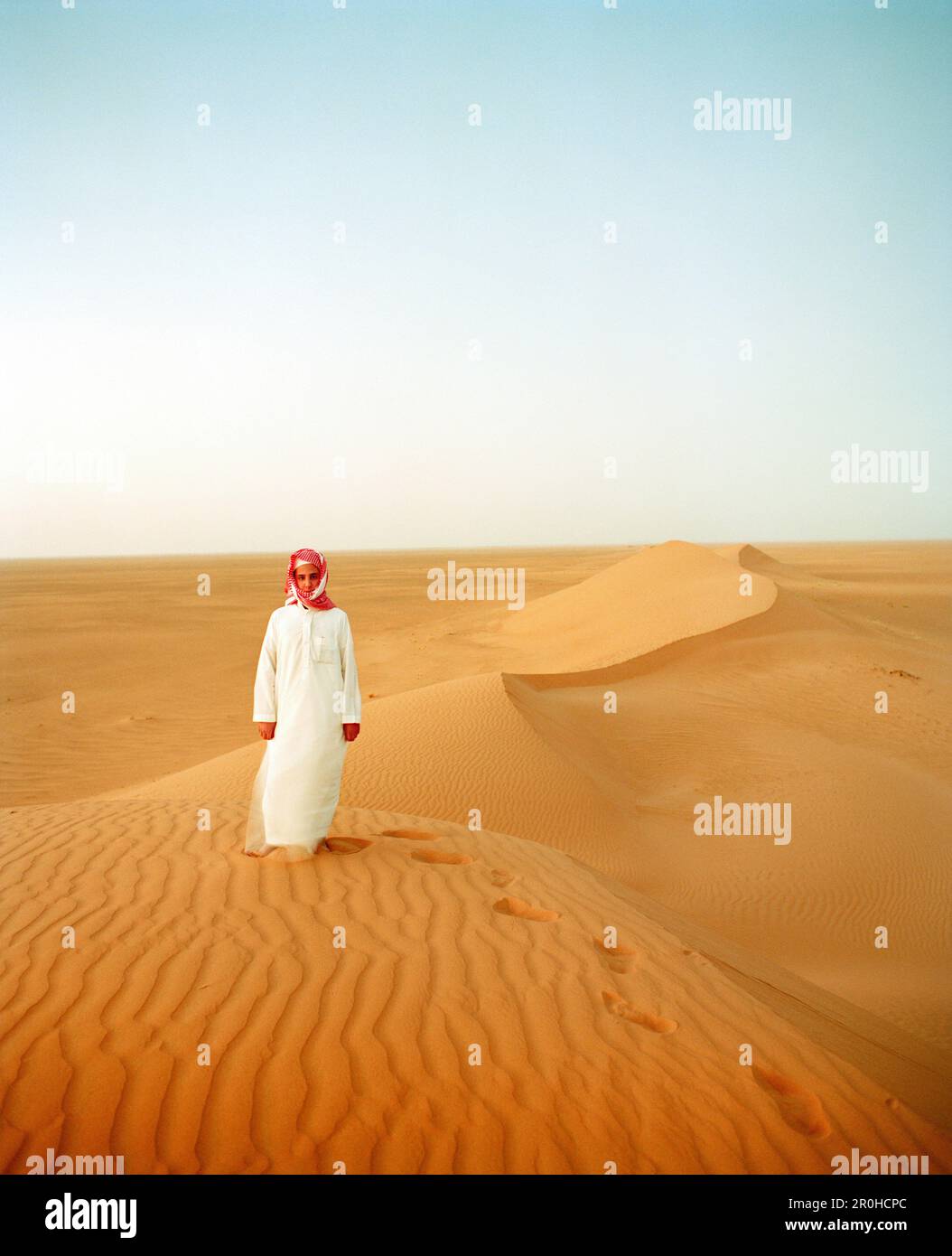 SAUDI ARABIA,The Empty Quarter, Najran, teenage boy standing on sand ...