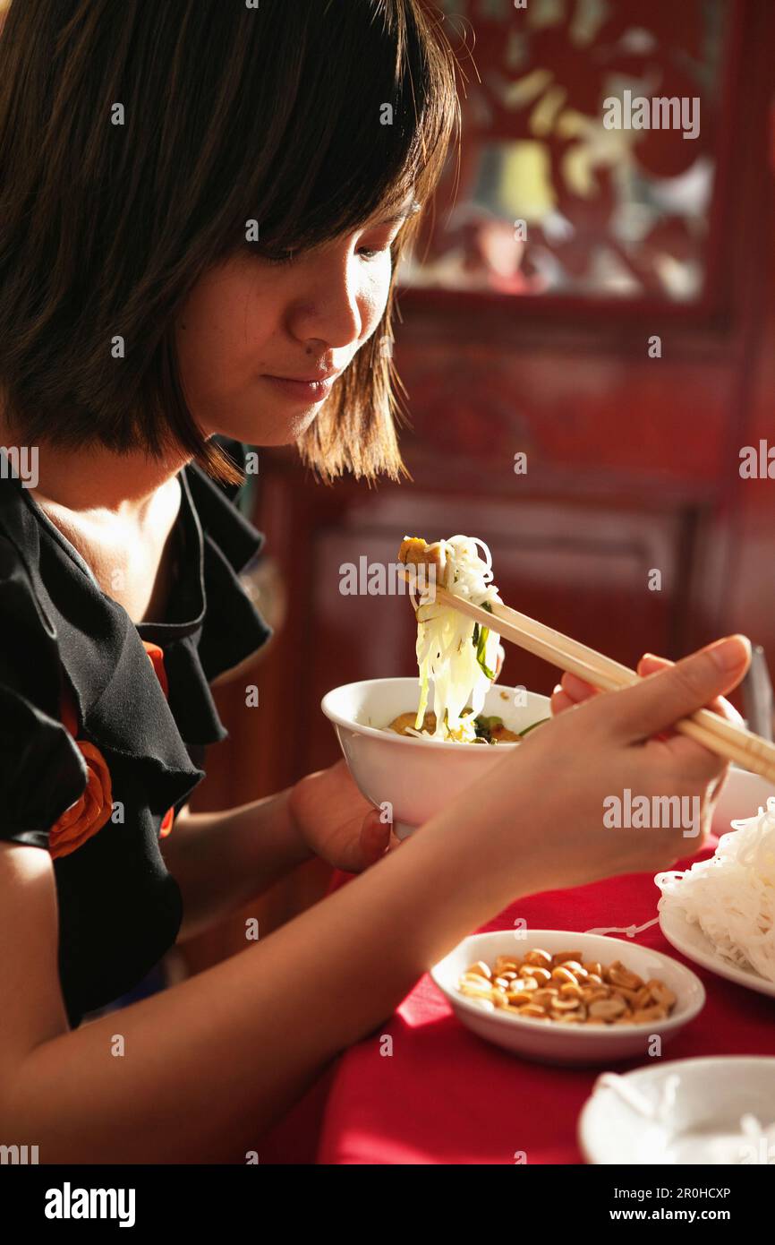 VIETNAM, Hanoi, Thuy takes a bite of noodles and fish at the famous Cha ...