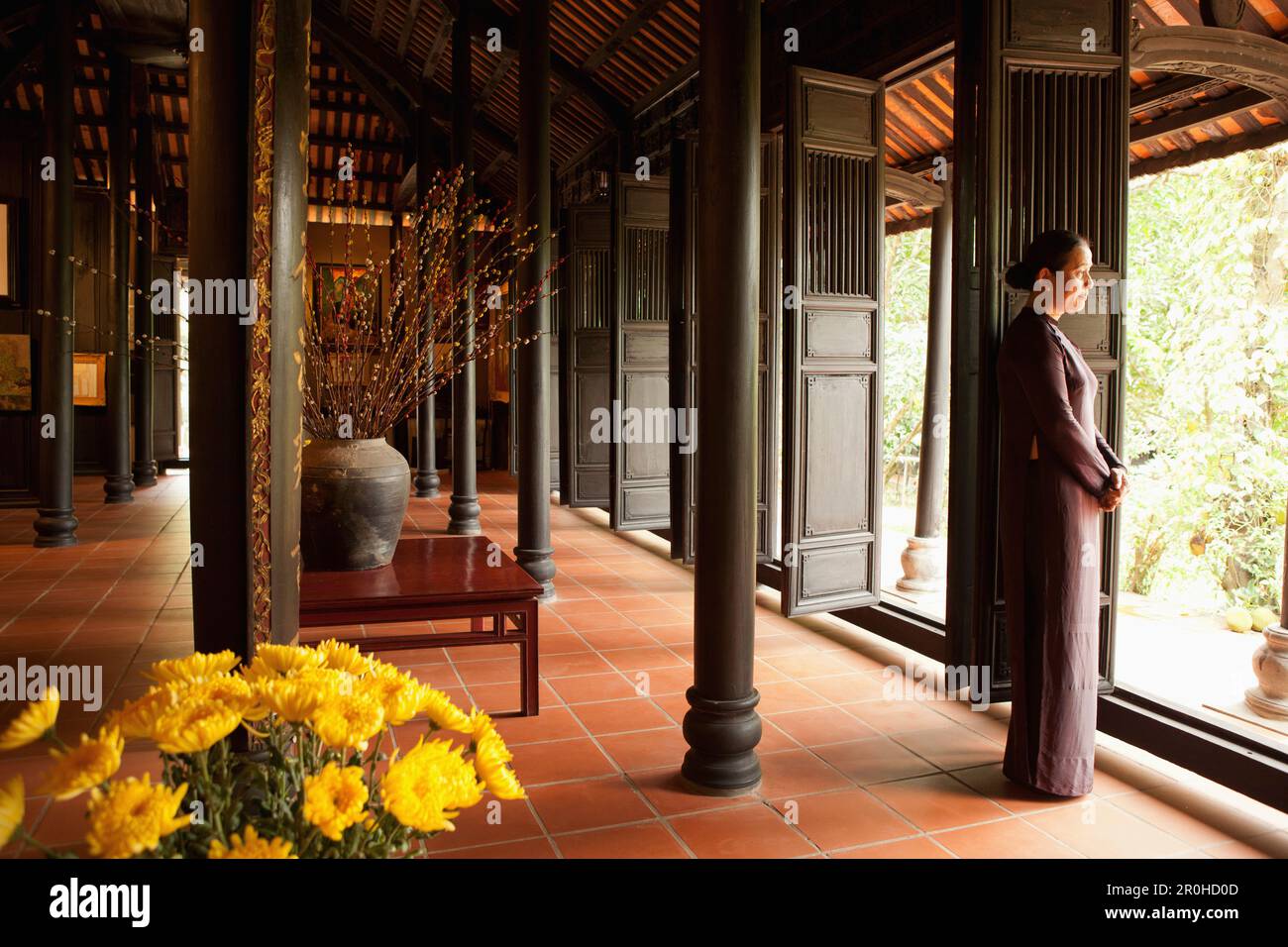 VIETNAM, Hue, Ms. Boi Tran standing in a beautiful room in her home ...