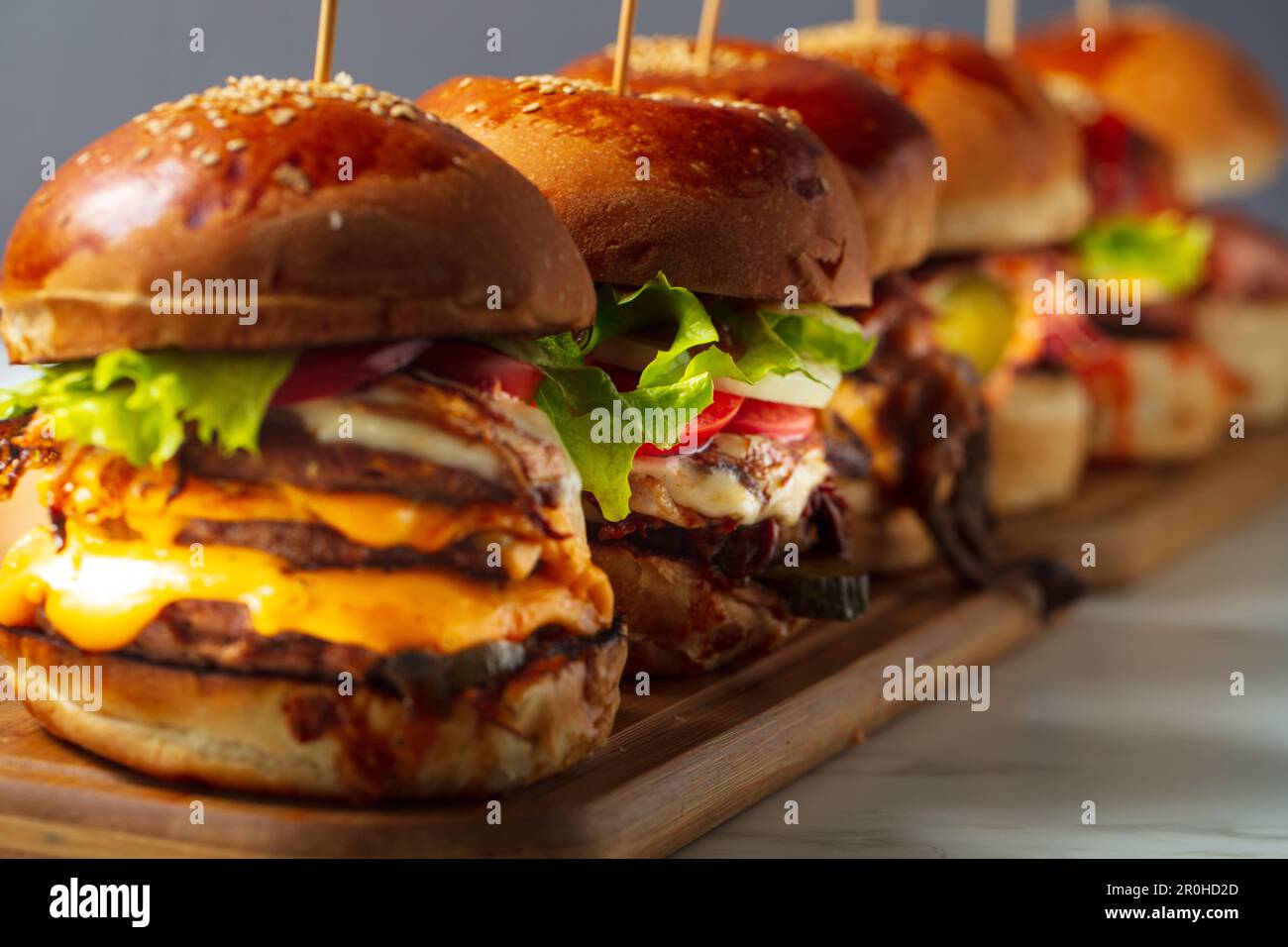 Many different burgers with ingredients on a wood plate Stock Photo - Alamy